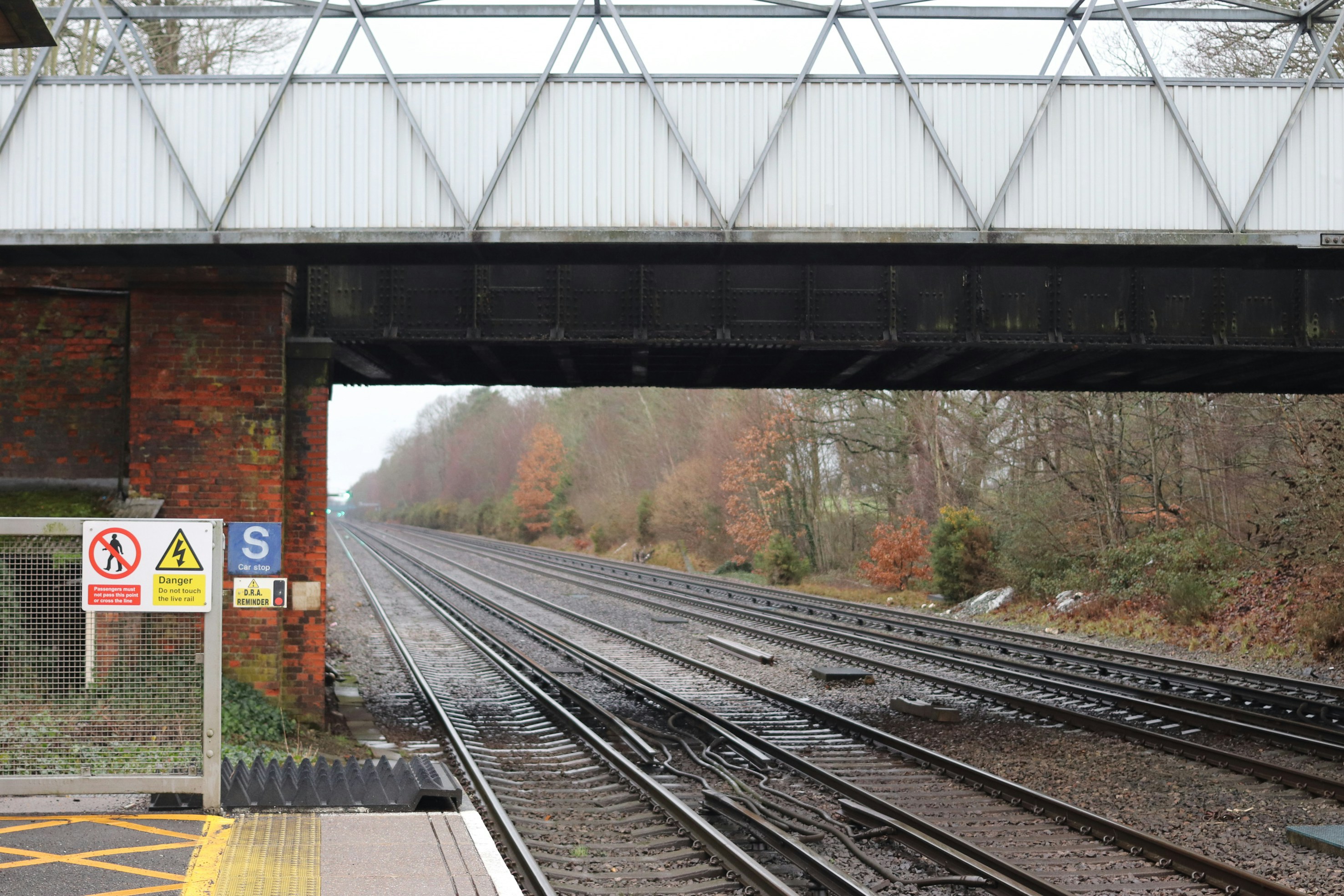 Under the steel arch: tracks fading into autumnal distance
