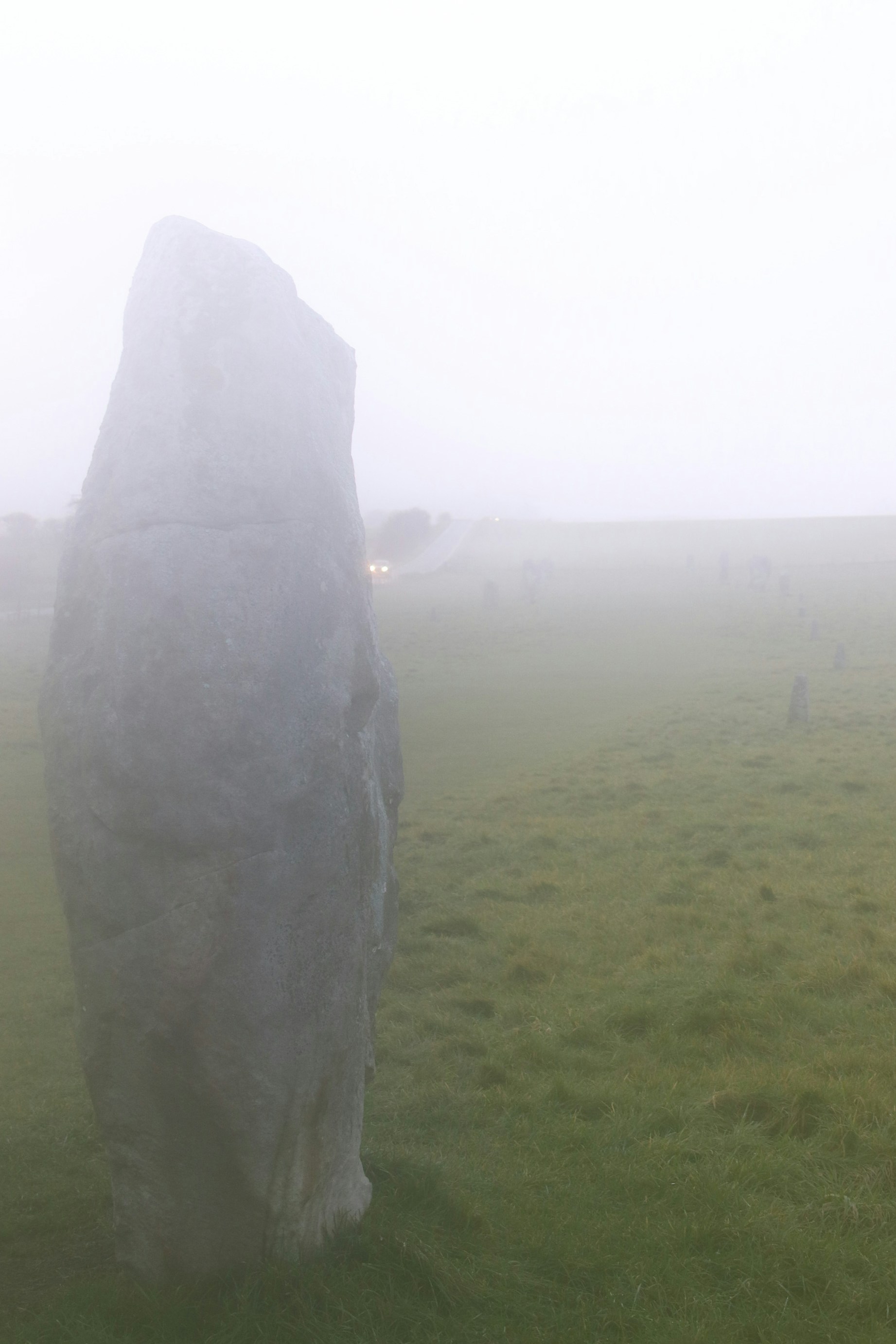 A large standing stone in a foggy field. photo – Free History Image on ...