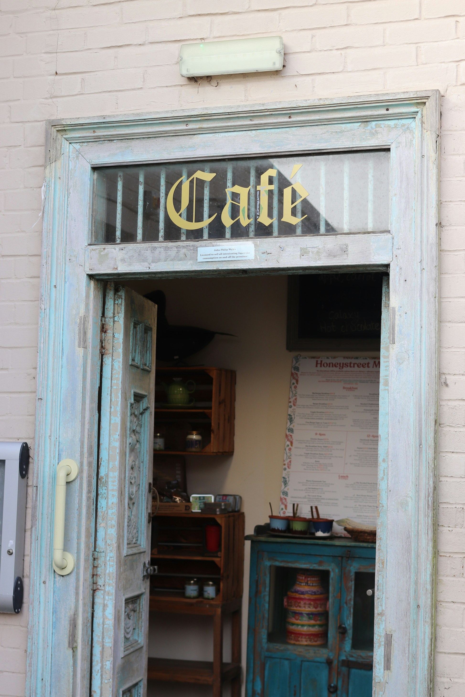 Weathered Café Doorway: A Nostalgic Teal Frame into Quiet Interiors