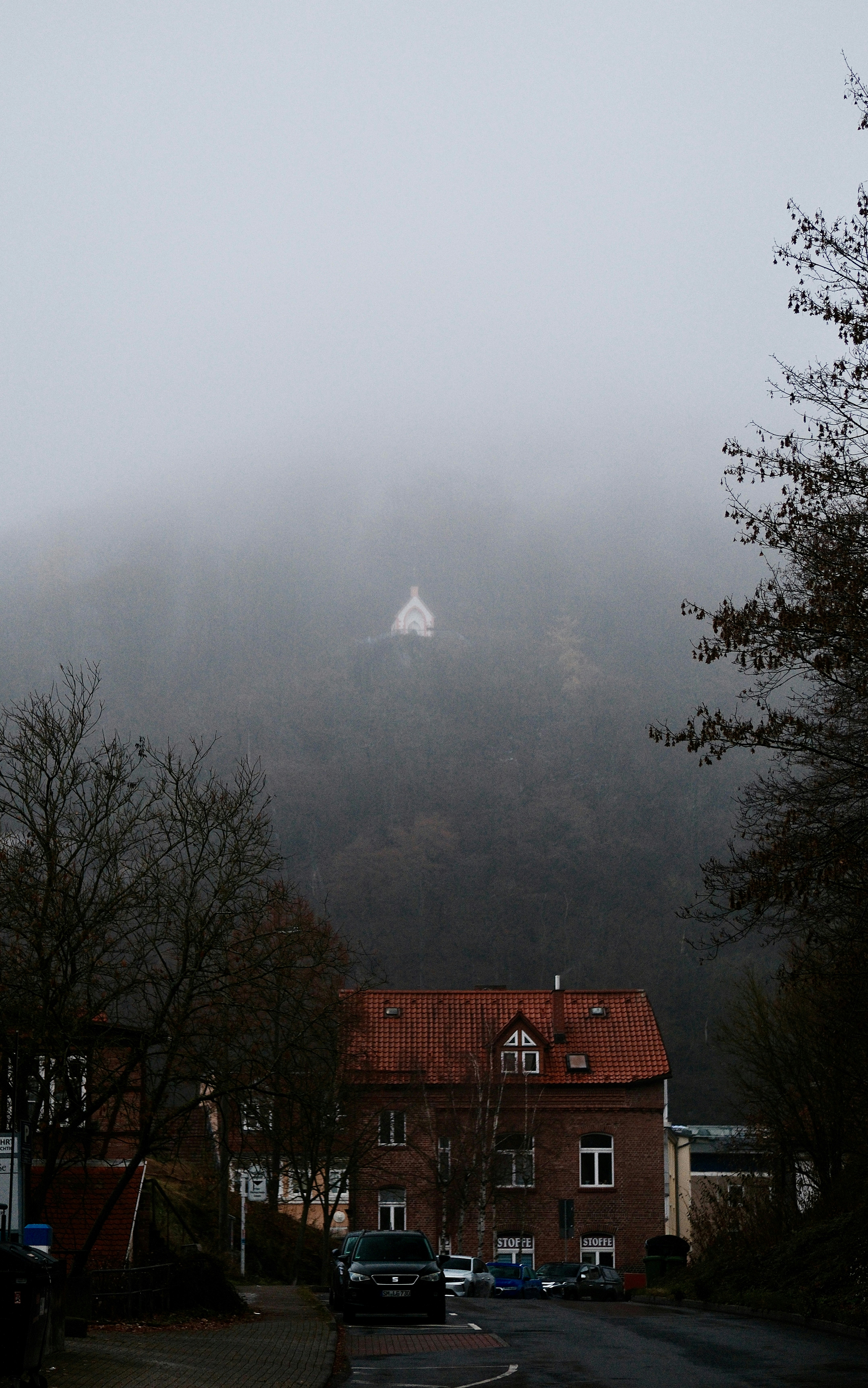 Mist on the Hills: A Quiet Church Silhouetted by Fog