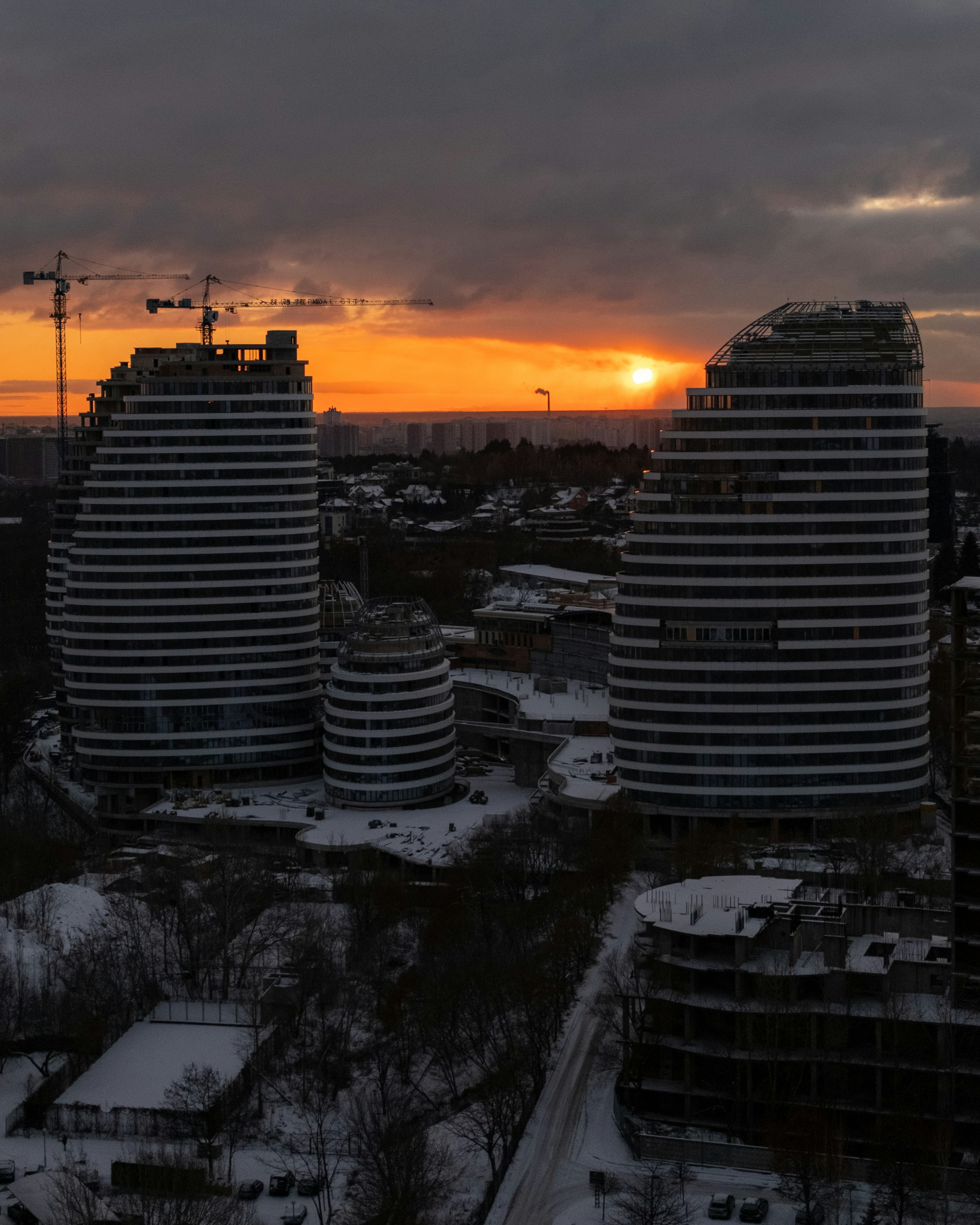 Sunset Over Curved Towers: Snow-Capped Skyline
