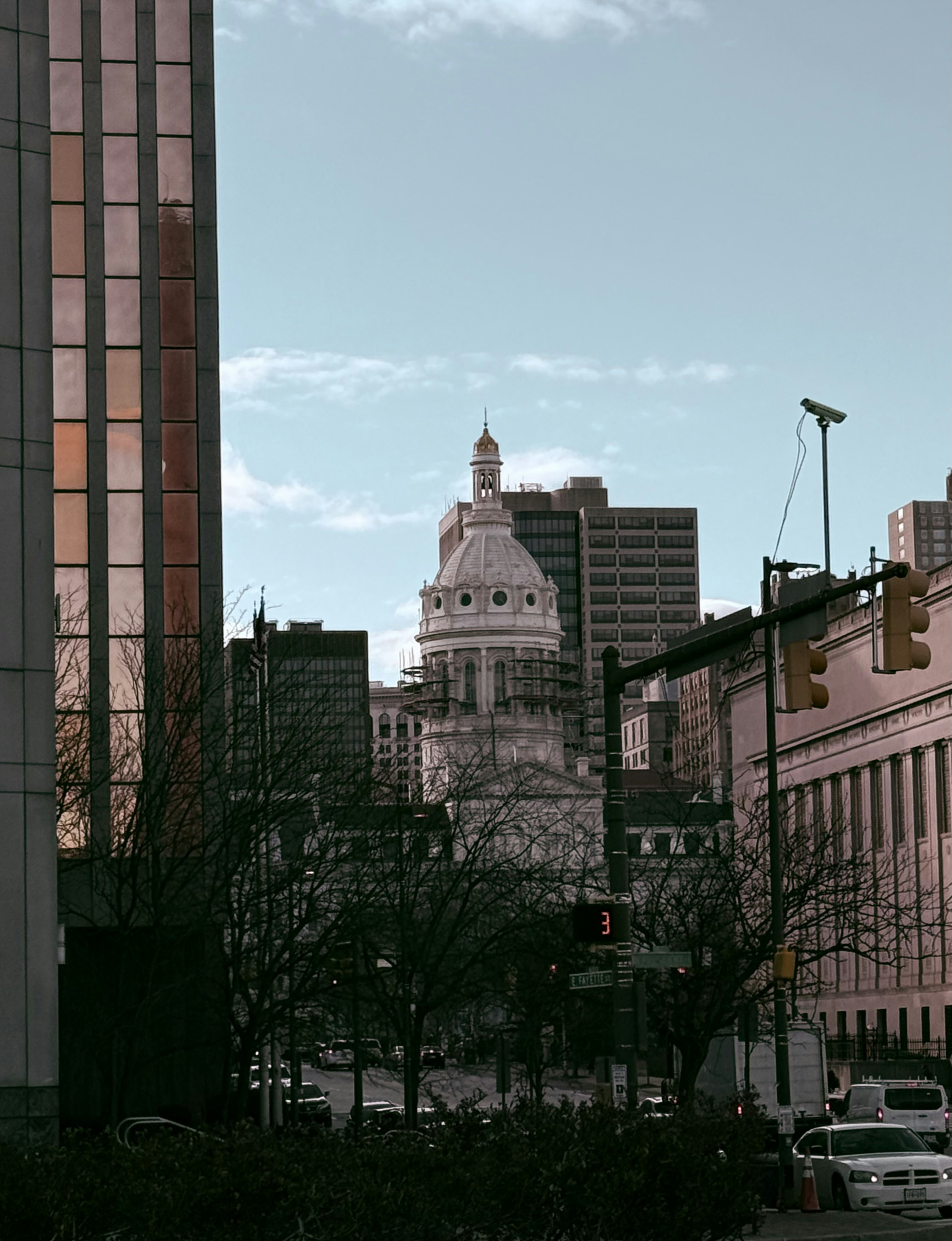 City Hall Peaks Through a Canyon of Glass and Traffic