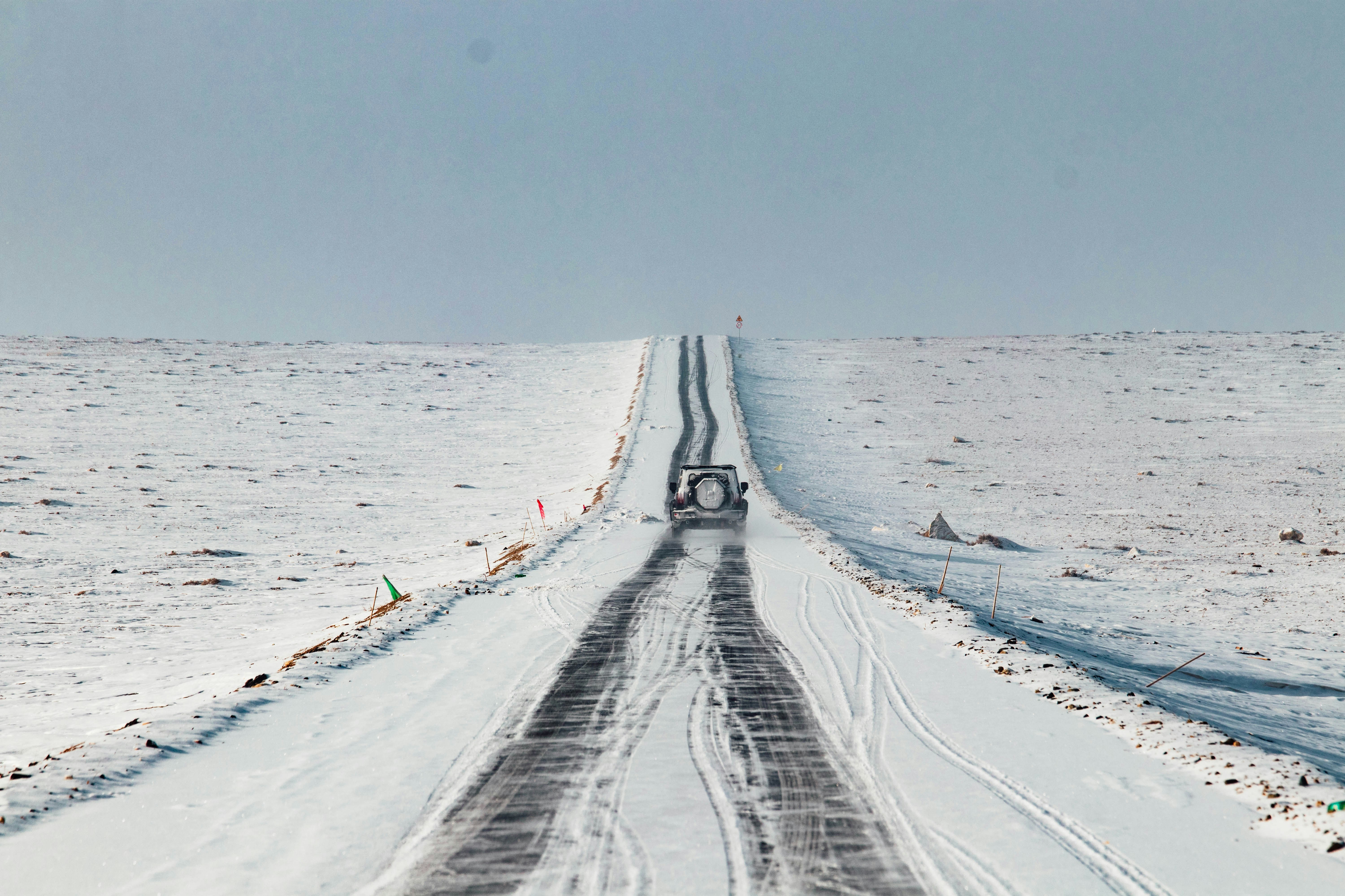 A long, straight road through a snowy, barren landscape. photo – Free ...