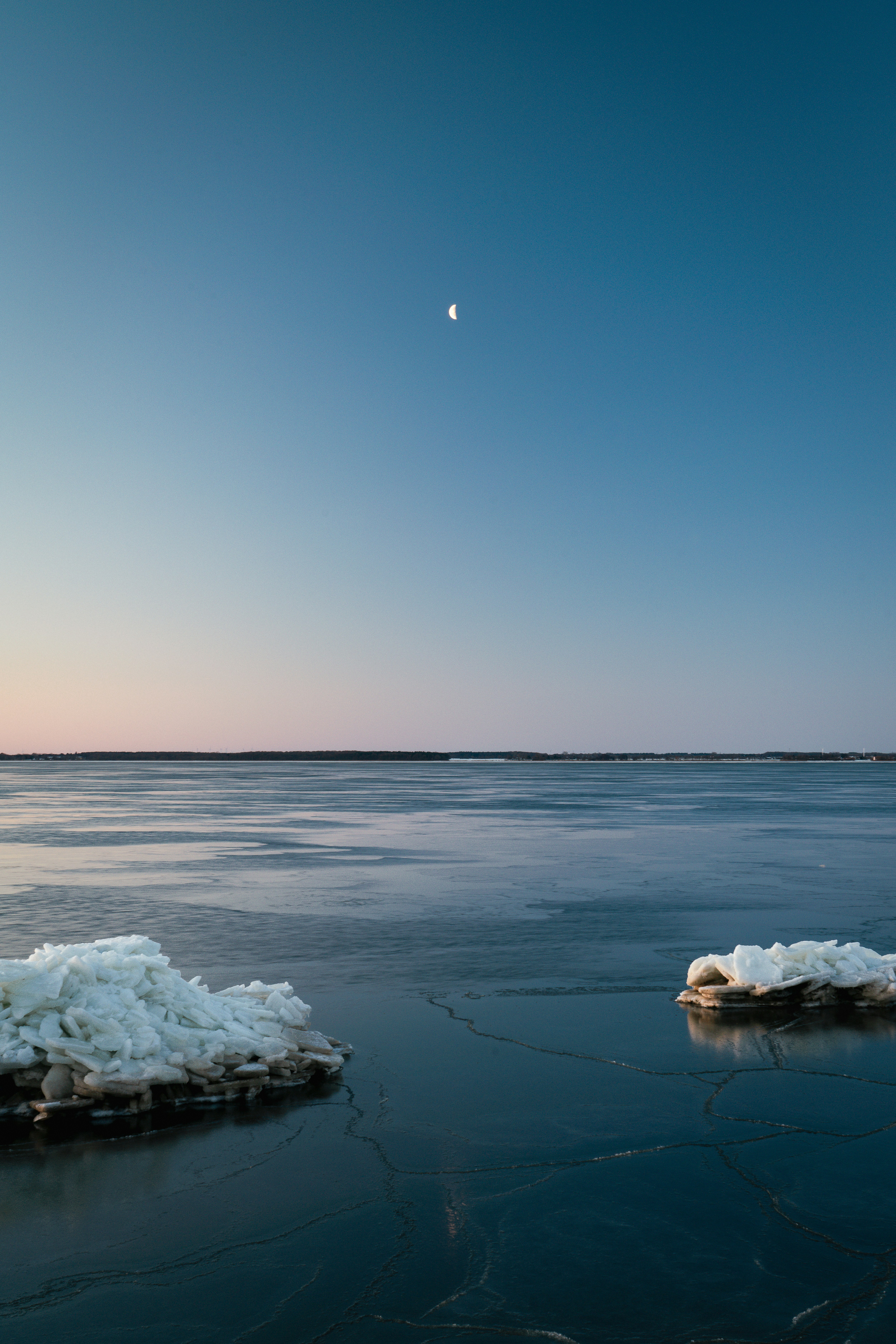 Dawn on a Fractured Sea: Ice Floes Beneath a Crescent Moon