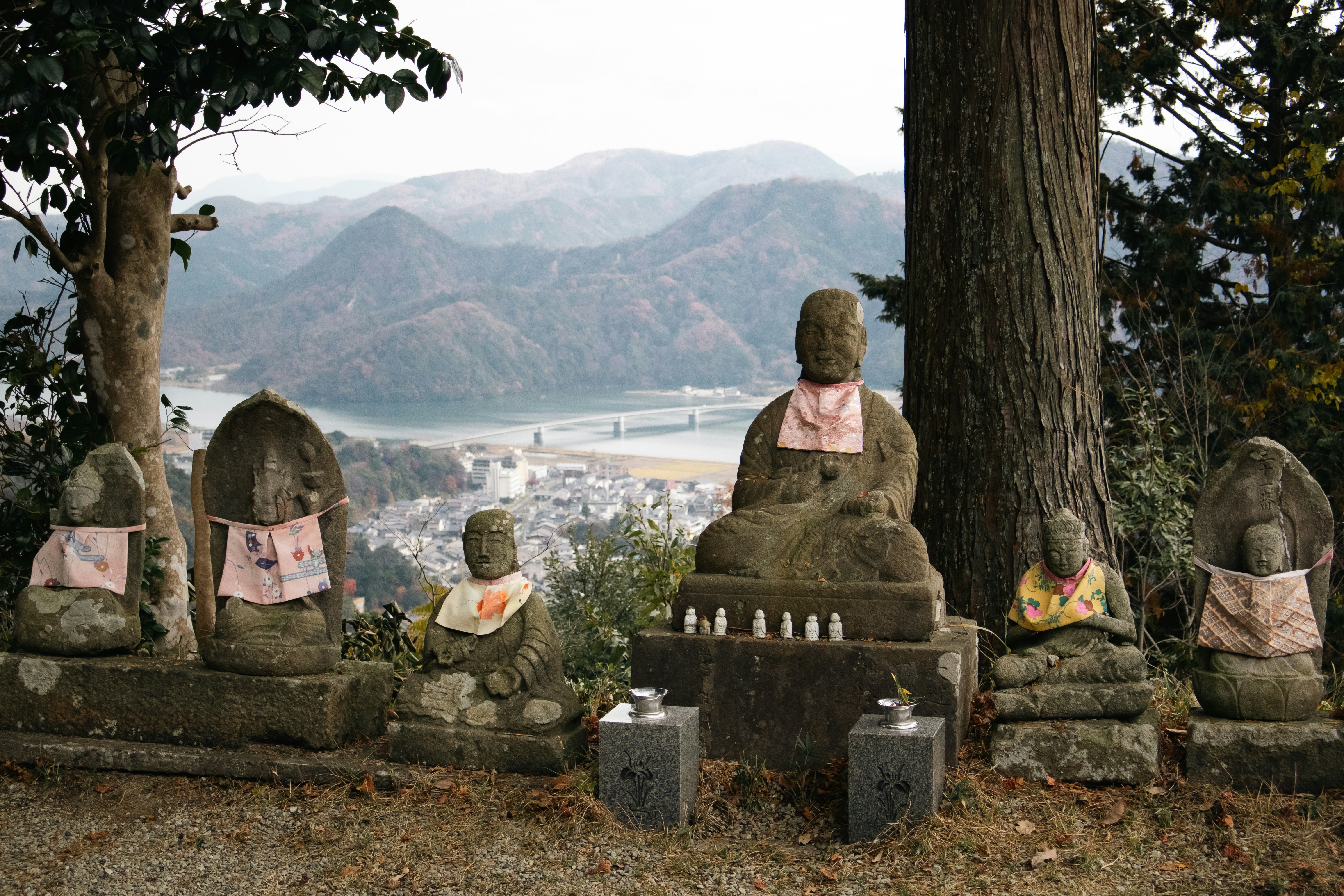 Row of Meditative Buddhas Overlooking a Mountain Town