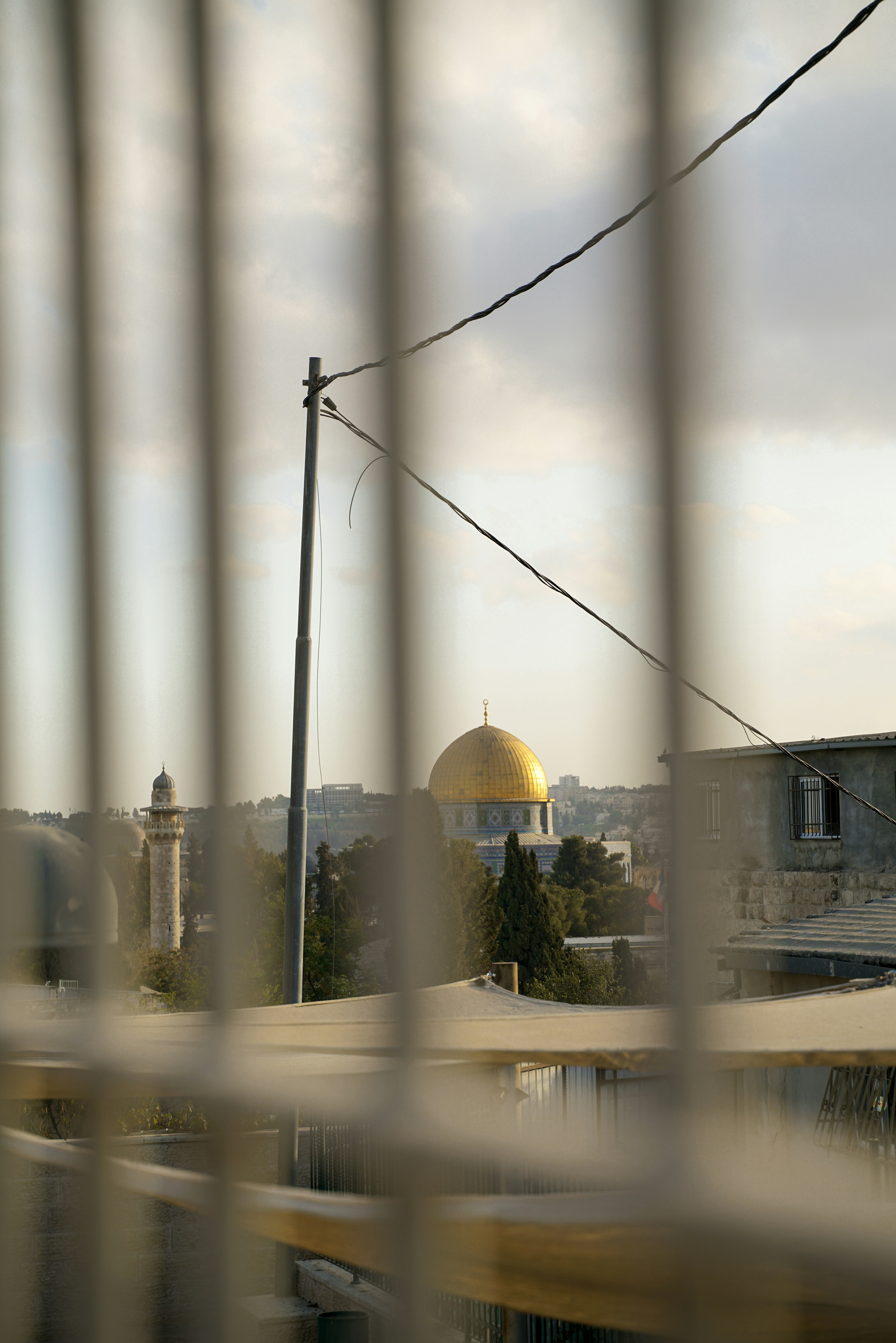 Golden Dome Through Slats: A Cityscape Framed by Bars
