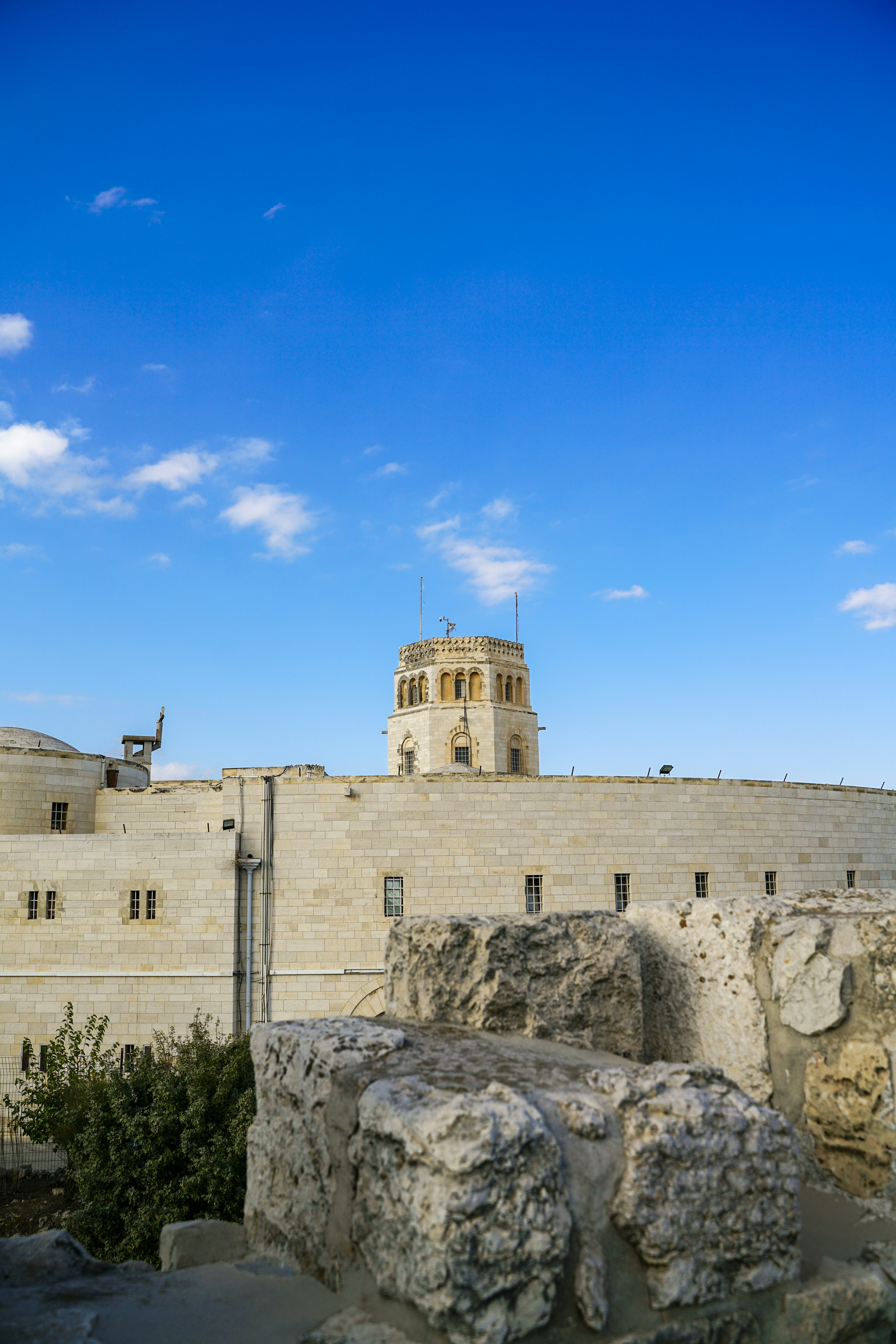 Fortress Crown: A Stone Tower Rising Above Ancient Walls Under a Clear Blue Sky