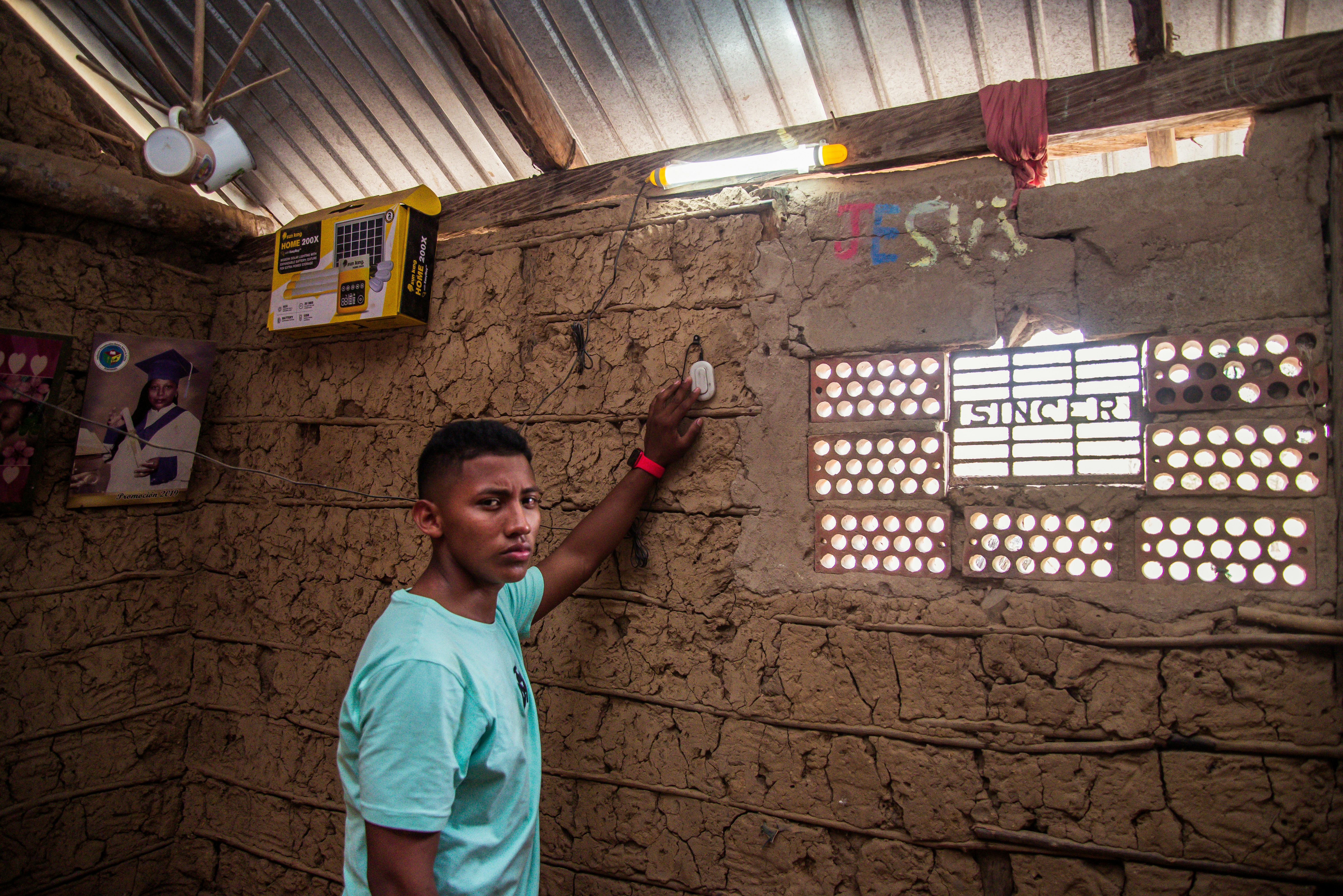 Young man points to a wall in a rustic room. photo – Free Young man ...