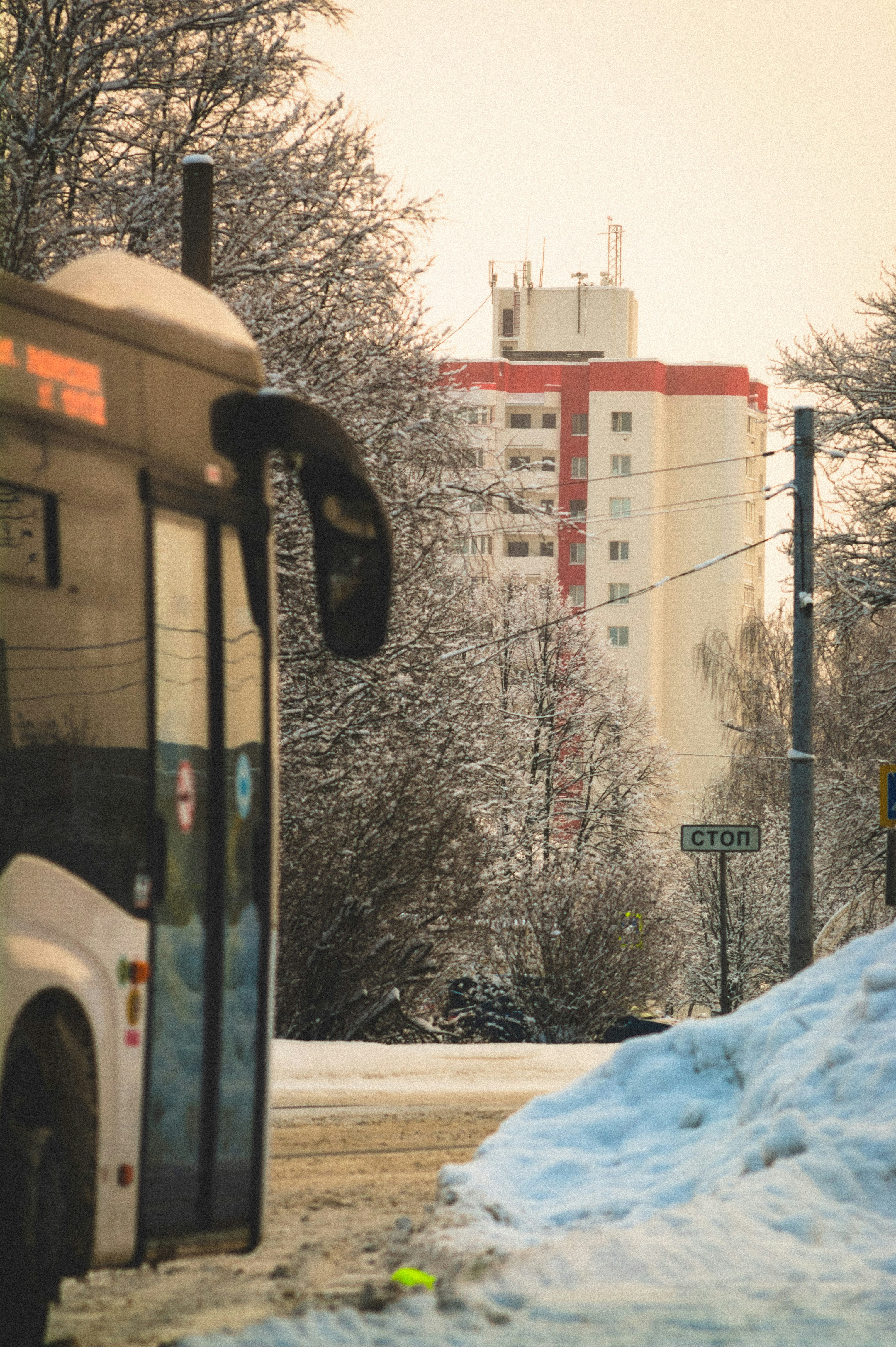 Bus on snowy street with building in background