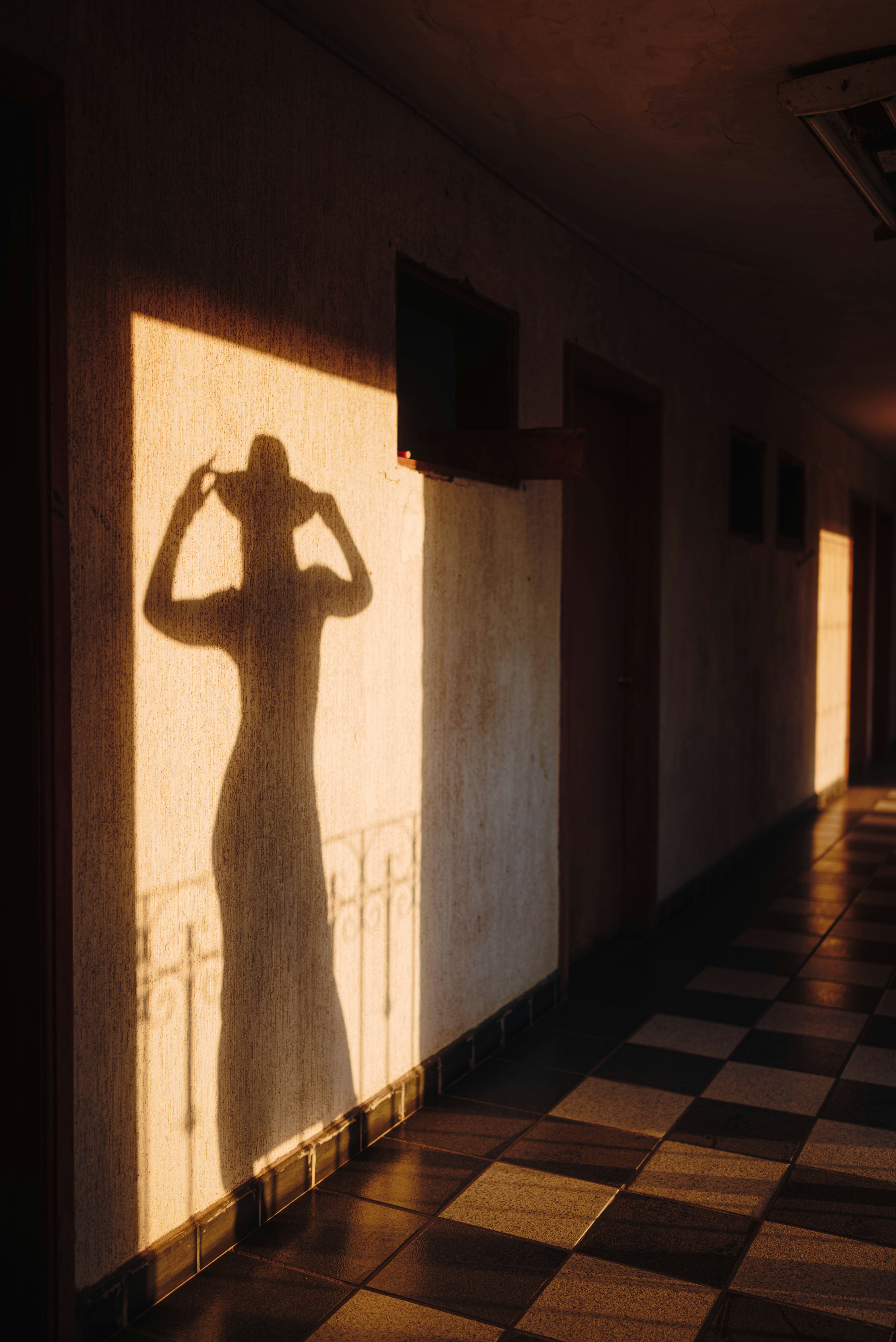 Shadow Play in the Corridor: A Silhouette at Golden Hour