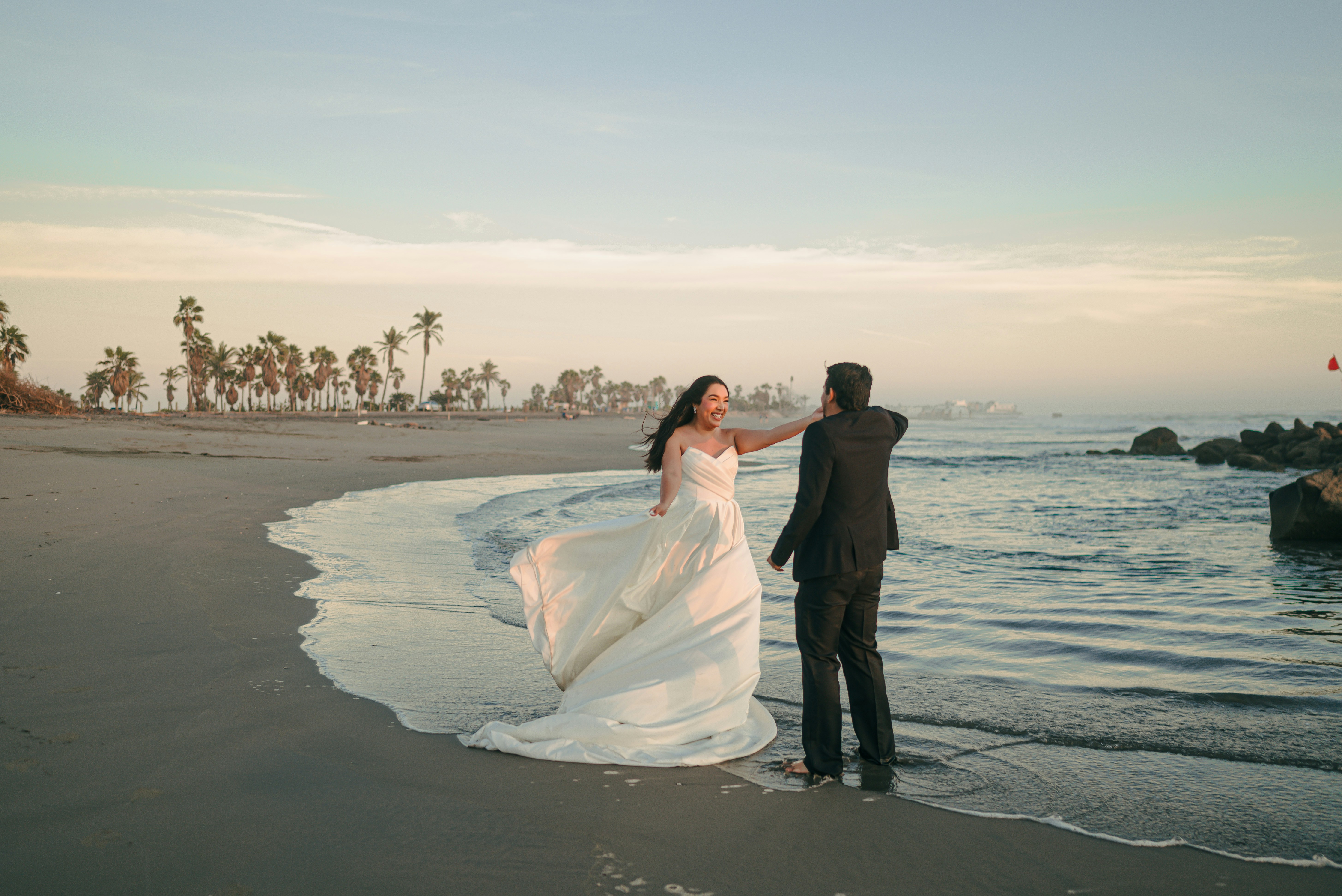 Bride and groom on a beach at sunset
