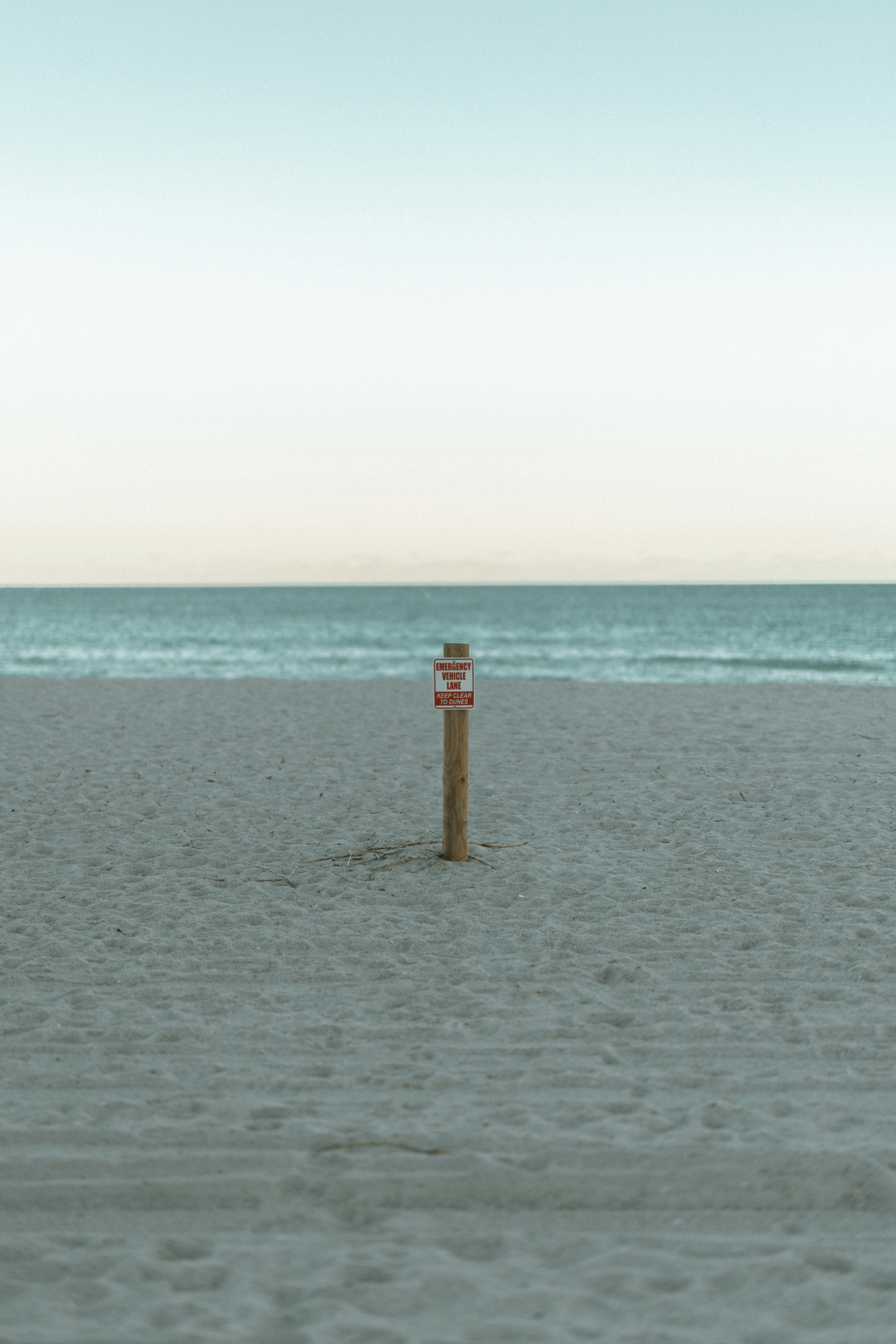 Lonely Beach Signpost Surrounded by Sea and Sand