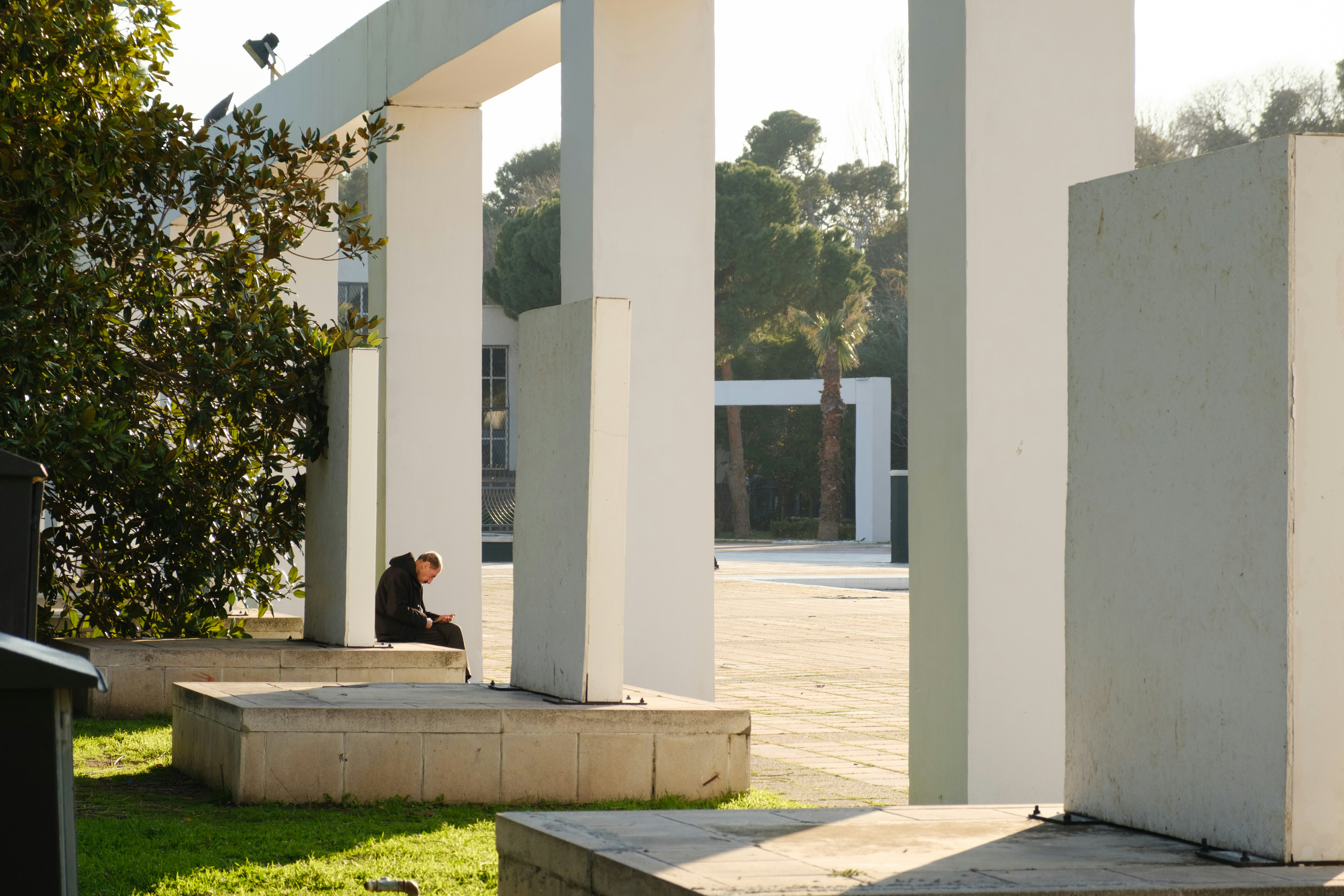 Solitary Figure Beneath Concrete Arcades