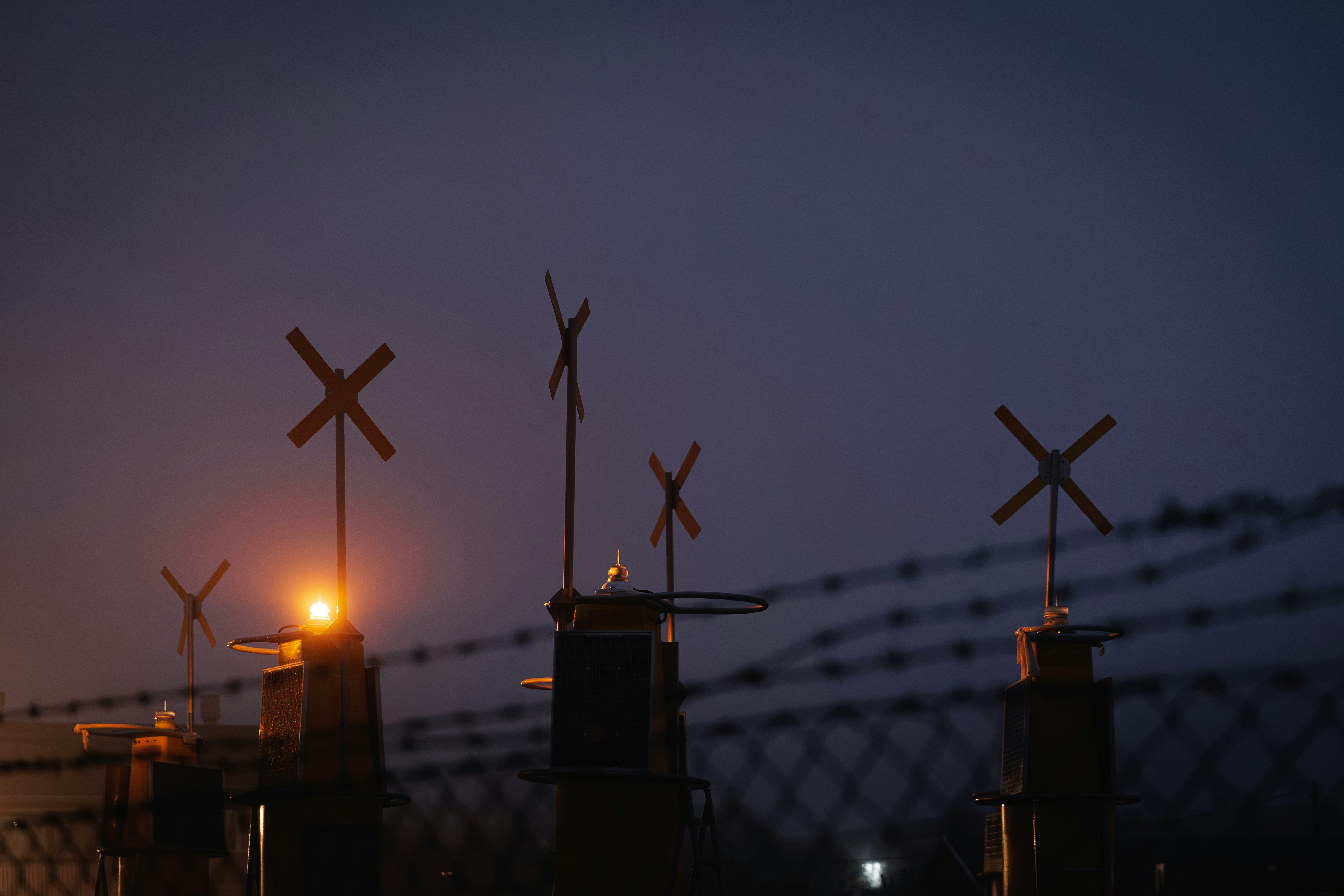 Quiet Night at the Tracks: Twilight Signal Posts on a Barbed‑Wire Horizon