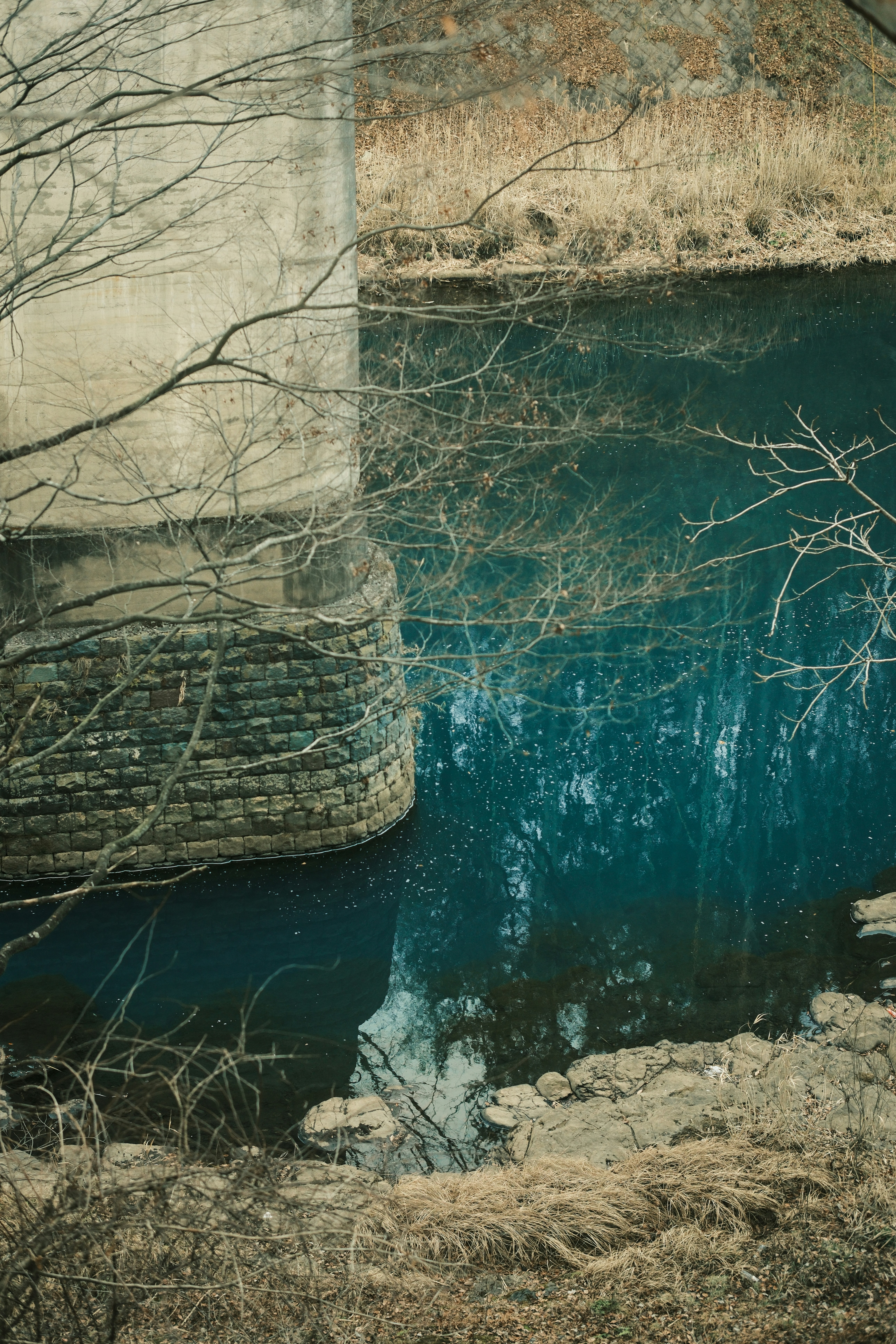 Bridge Pillar Over a Quiet River: Winter Reflections