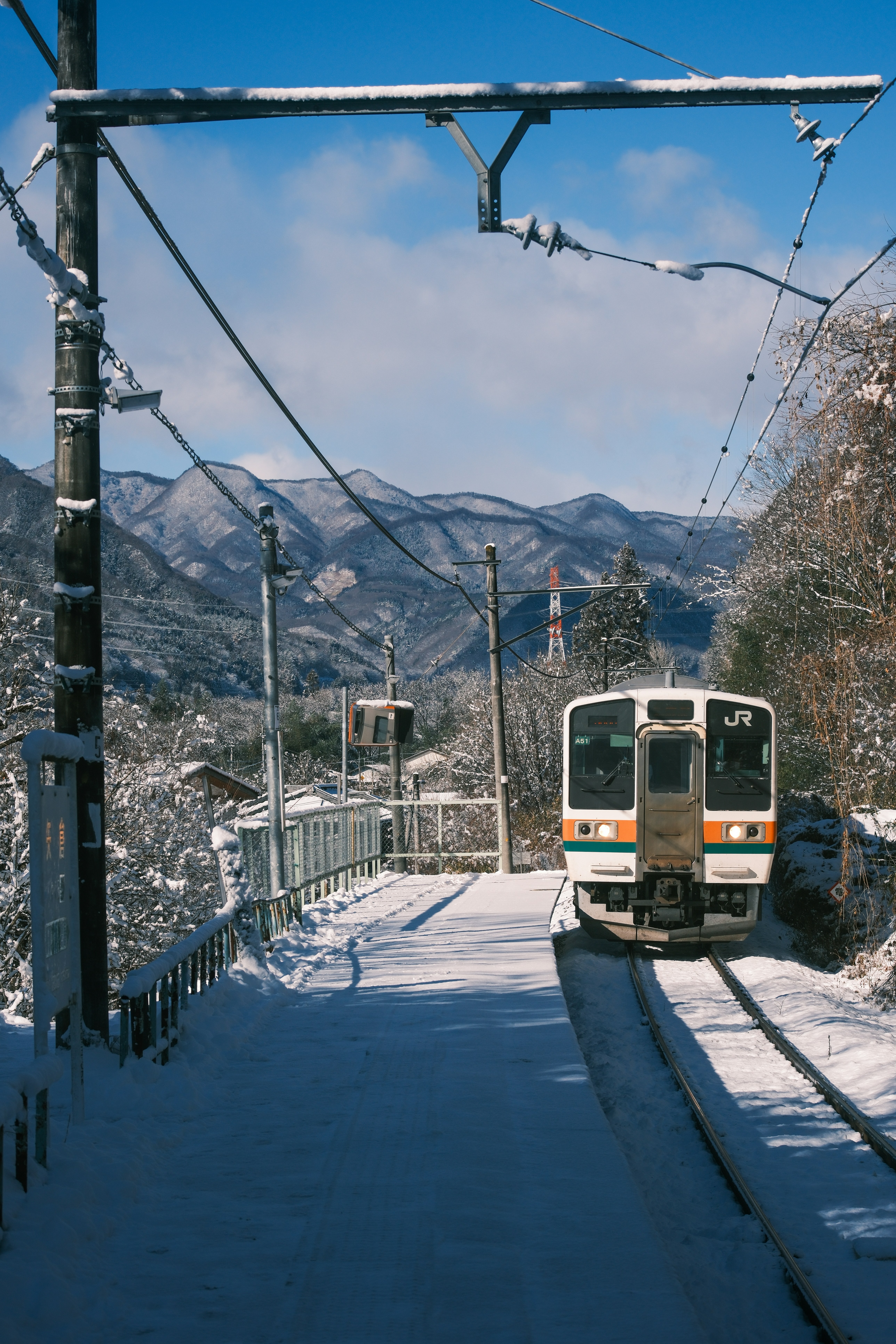 Snowbound Rails: A lone JR train winds toward the mountains