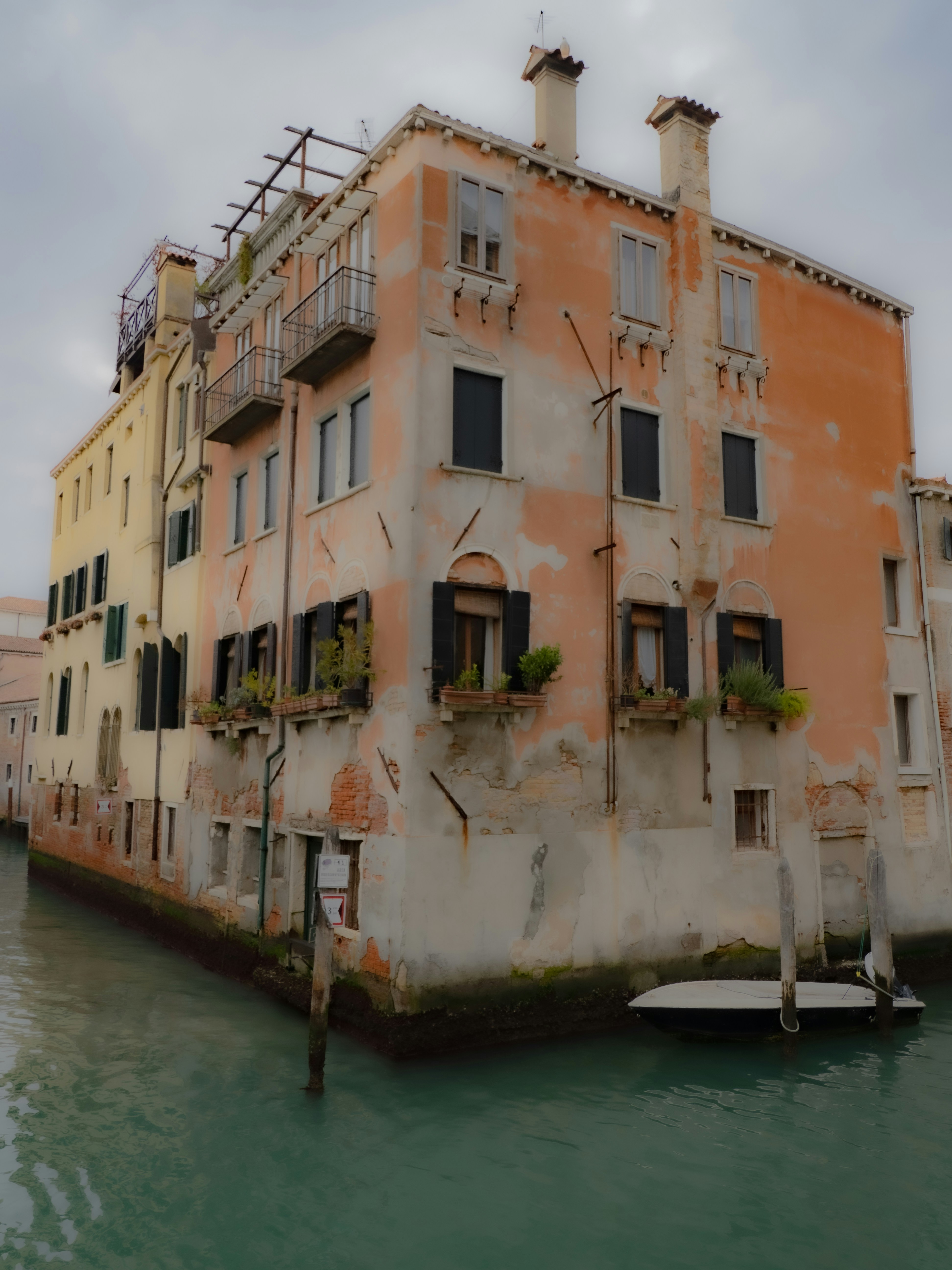 Weathered Venetian Dockside: Peach Facade Rising Over Tall Canal