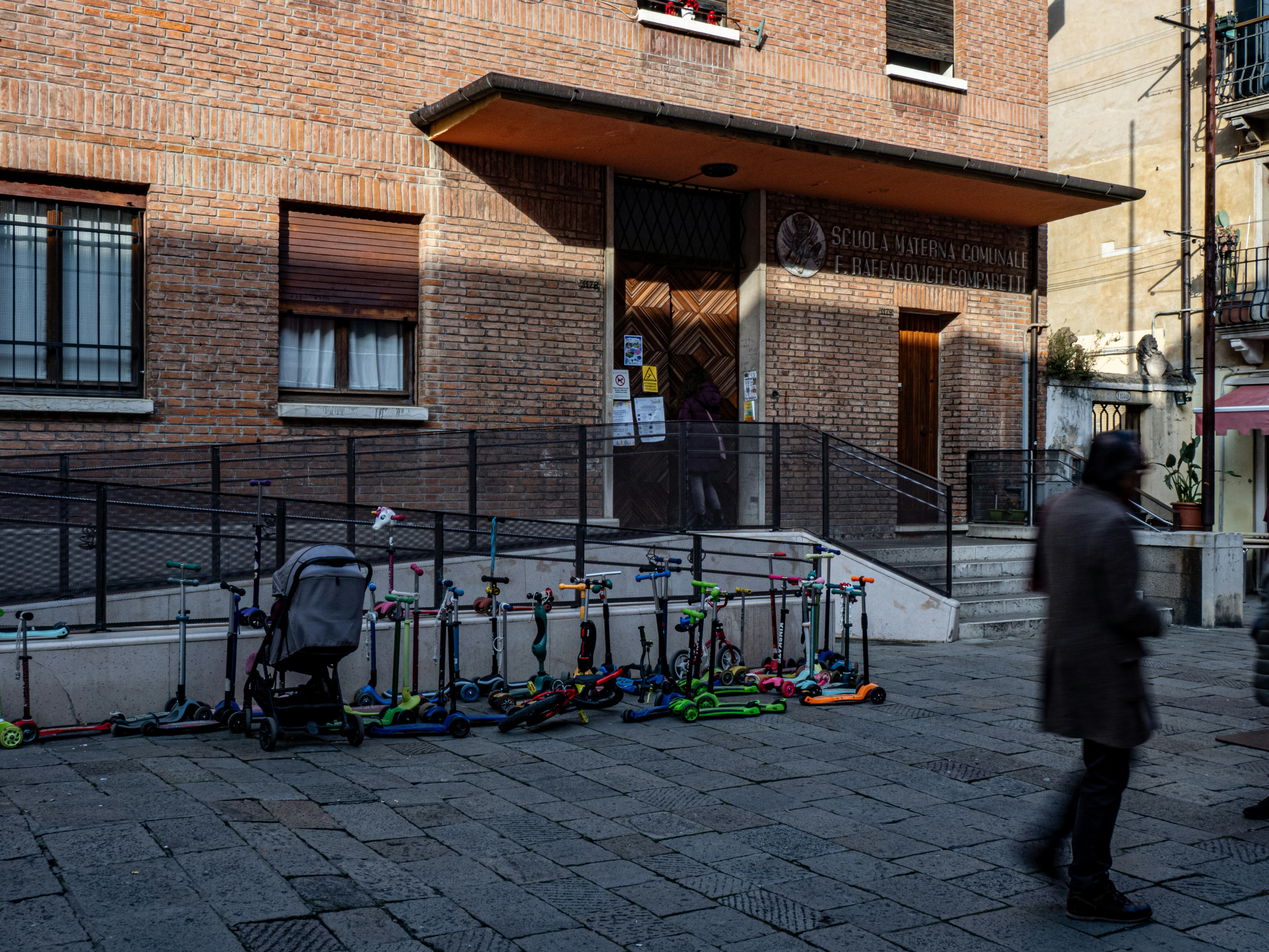 Scooters on the ledge outside a brick apartment building