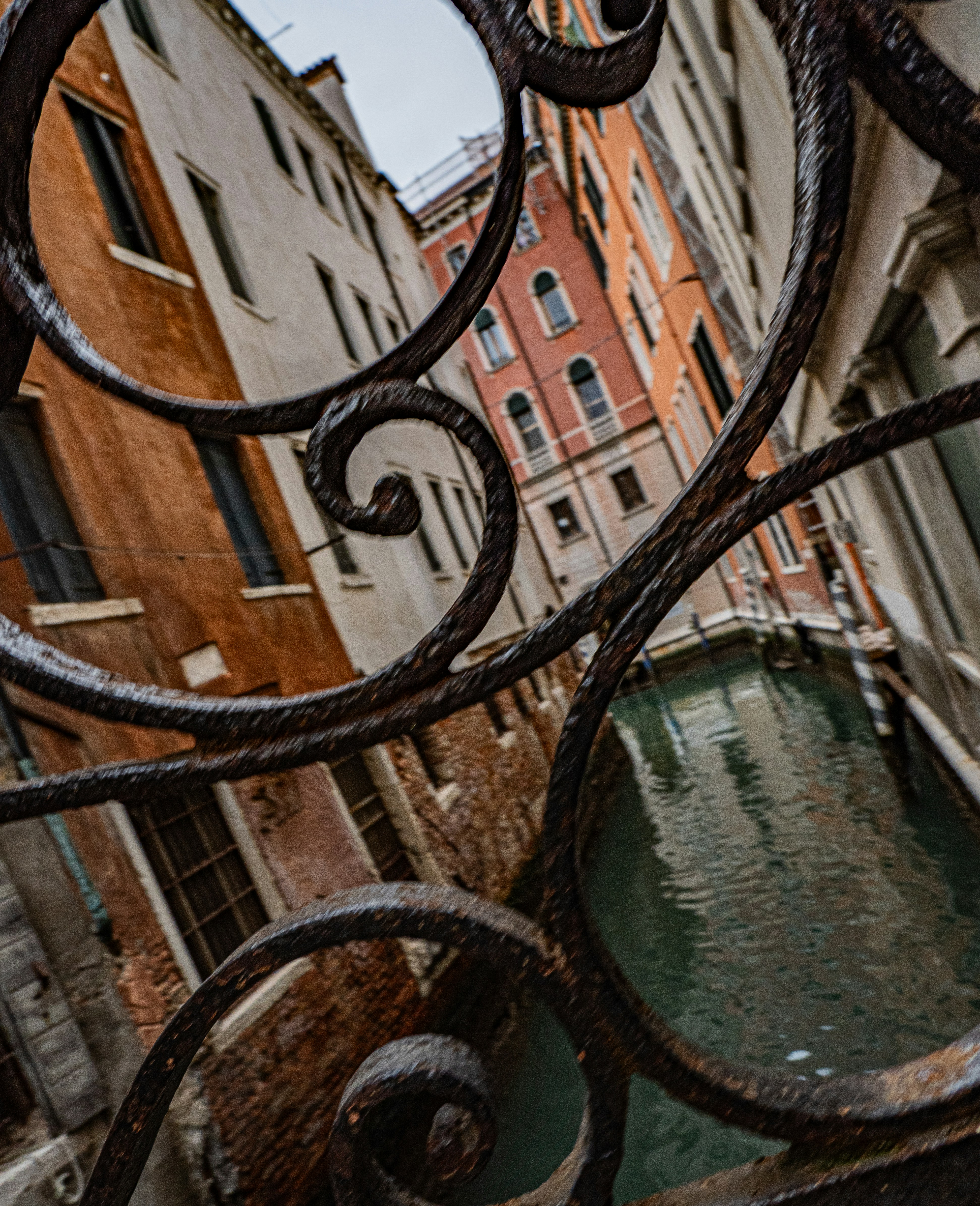 Canted View Through Wrought Iron: A Venetian Canal Scene