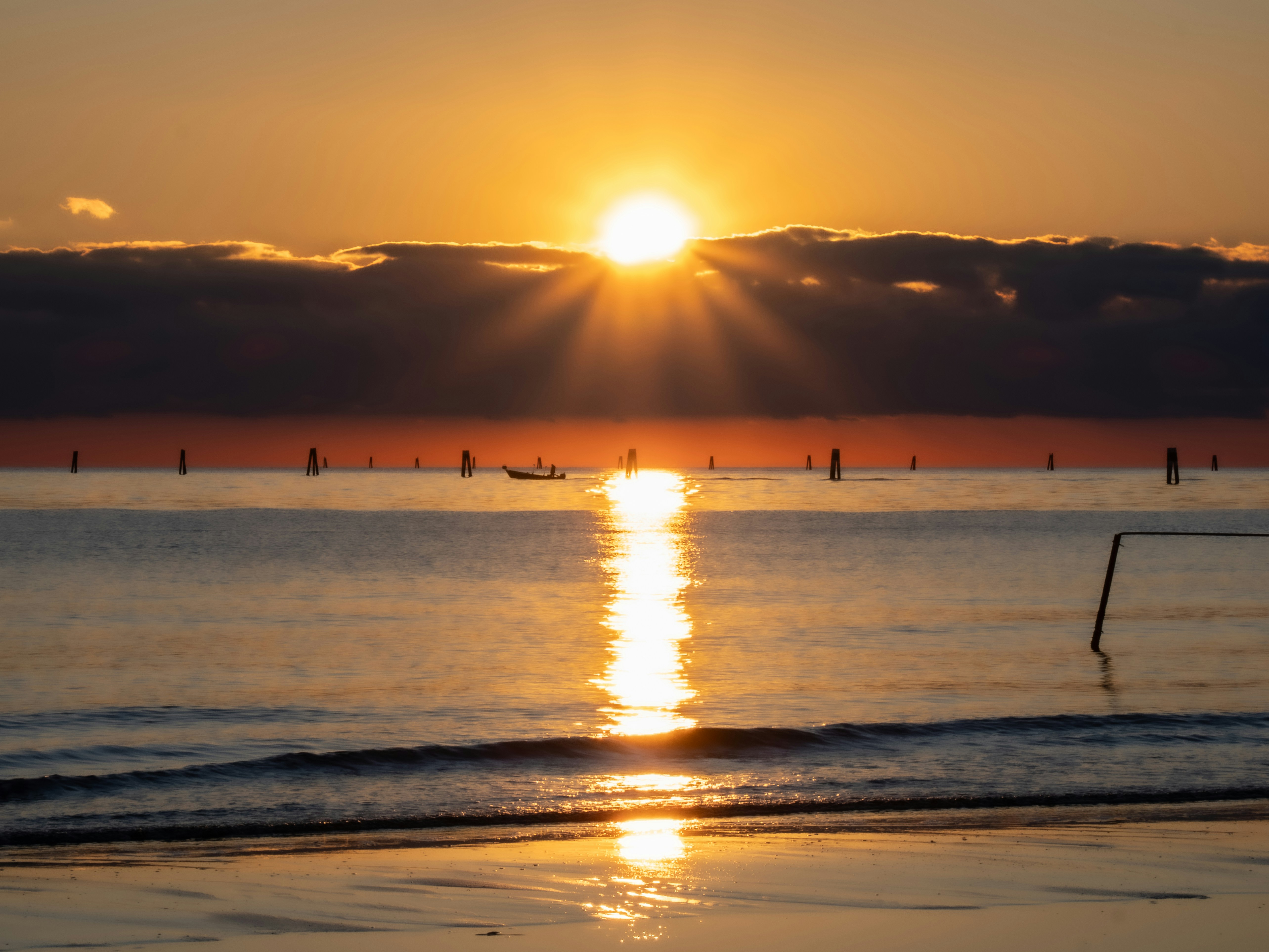 Golden Horizon: Sunrise over Calm Seas with Silhouette Buoys