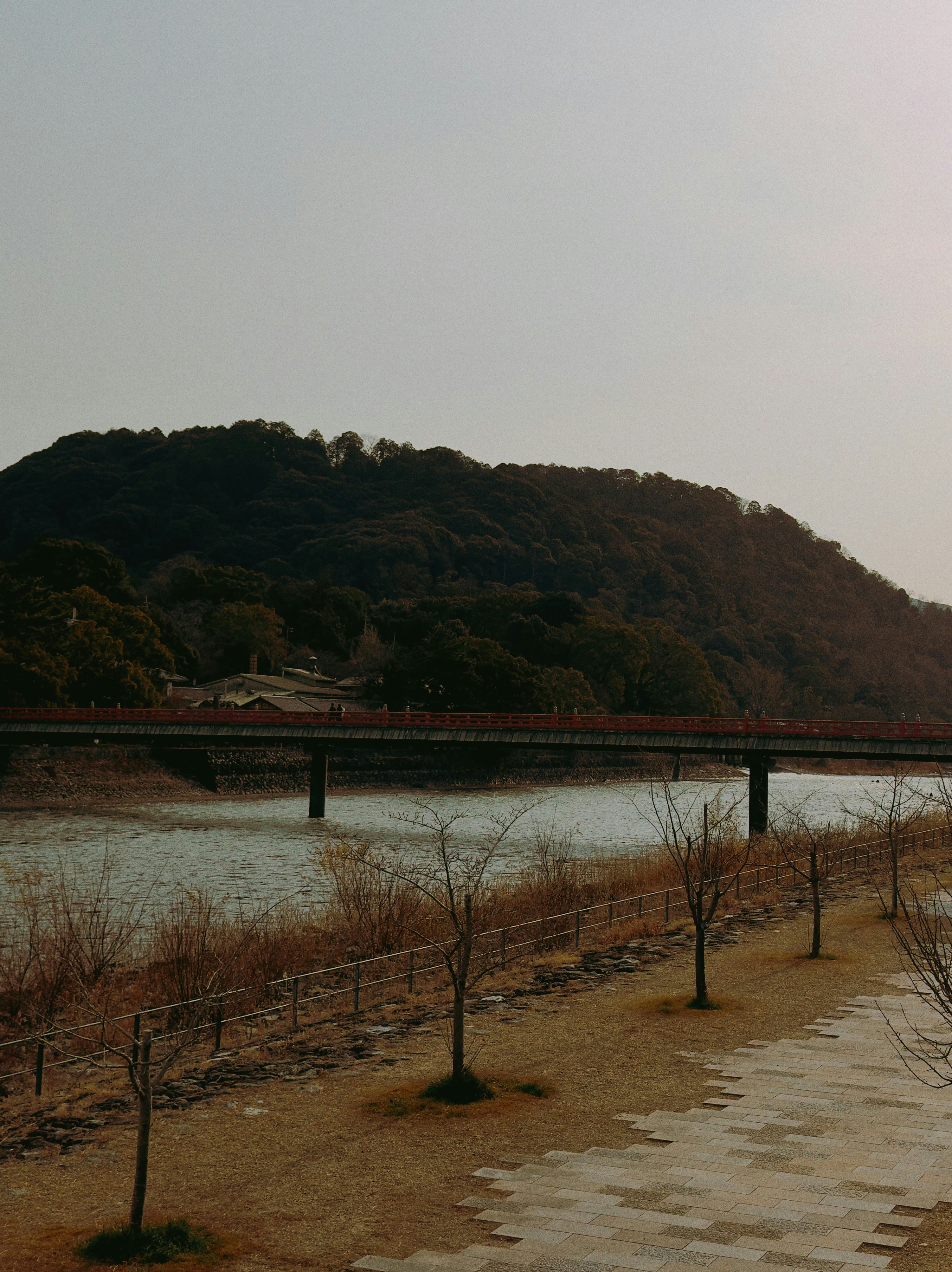 Bridge Across Quiet River Beneath a Hushed Hillside
