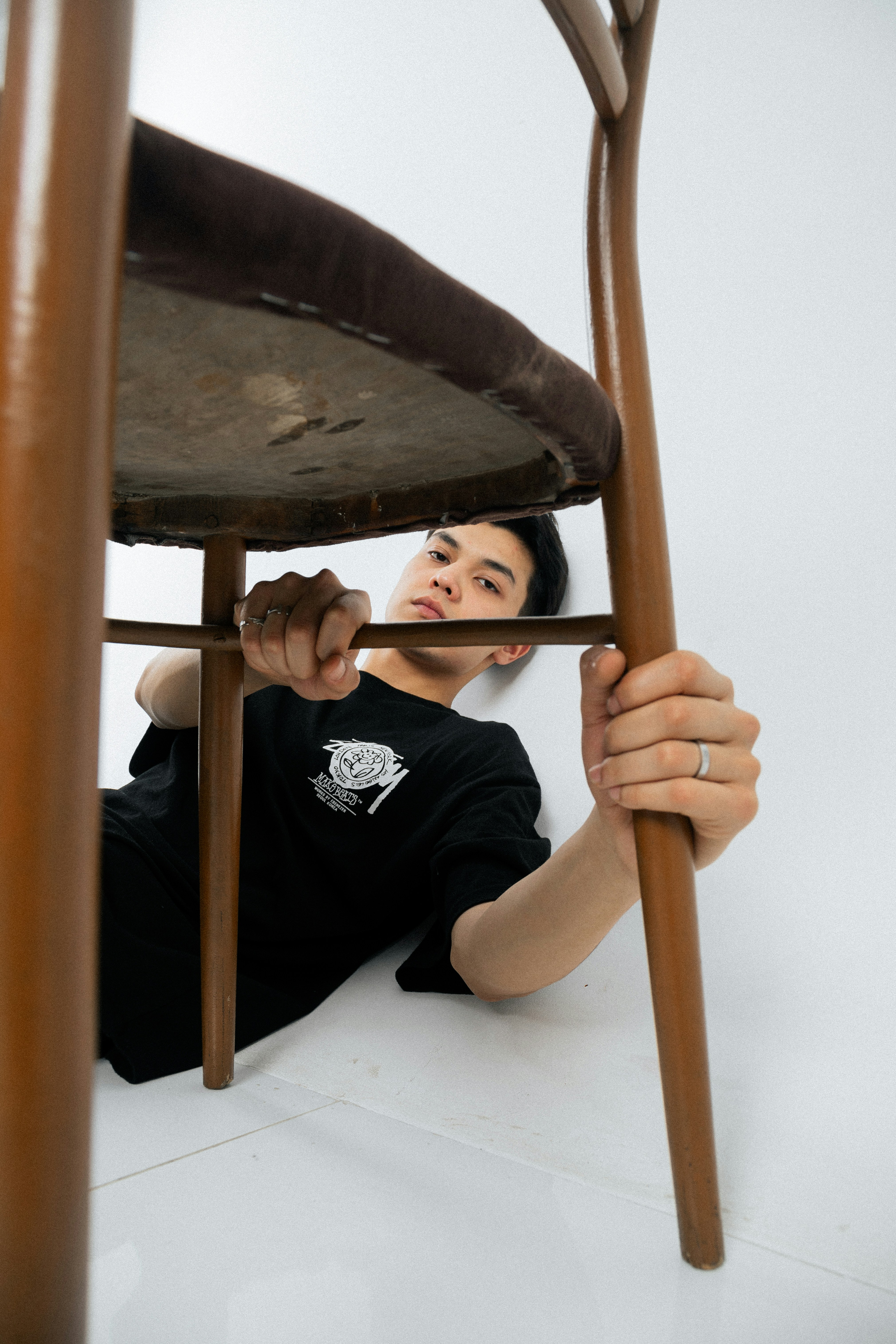 Under the Chair: A Low-Angle Portrait Emerging from the Frame