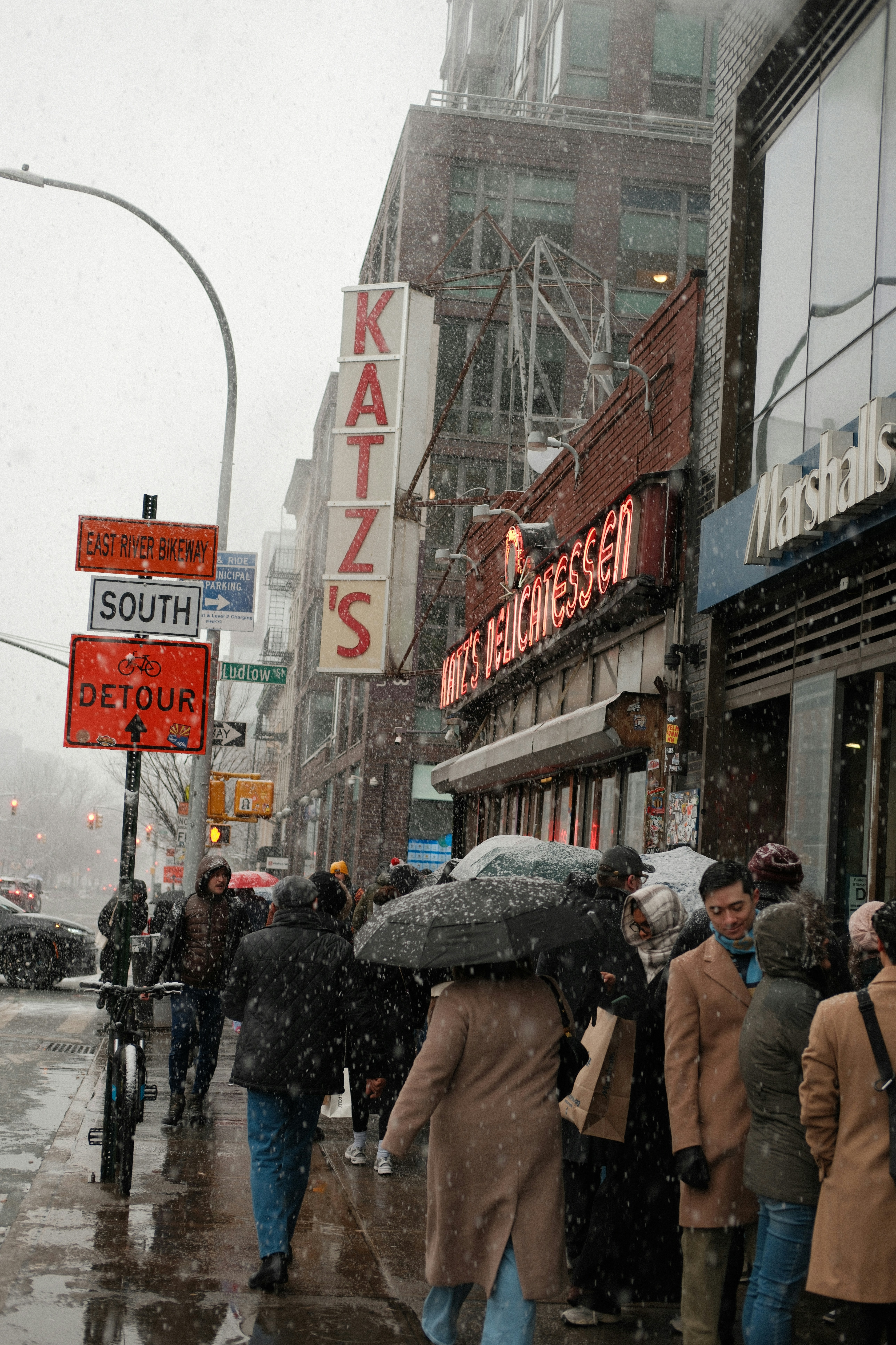 Snowy Street Pulse: Katz’s Neon Glow Amid a Winter Parade