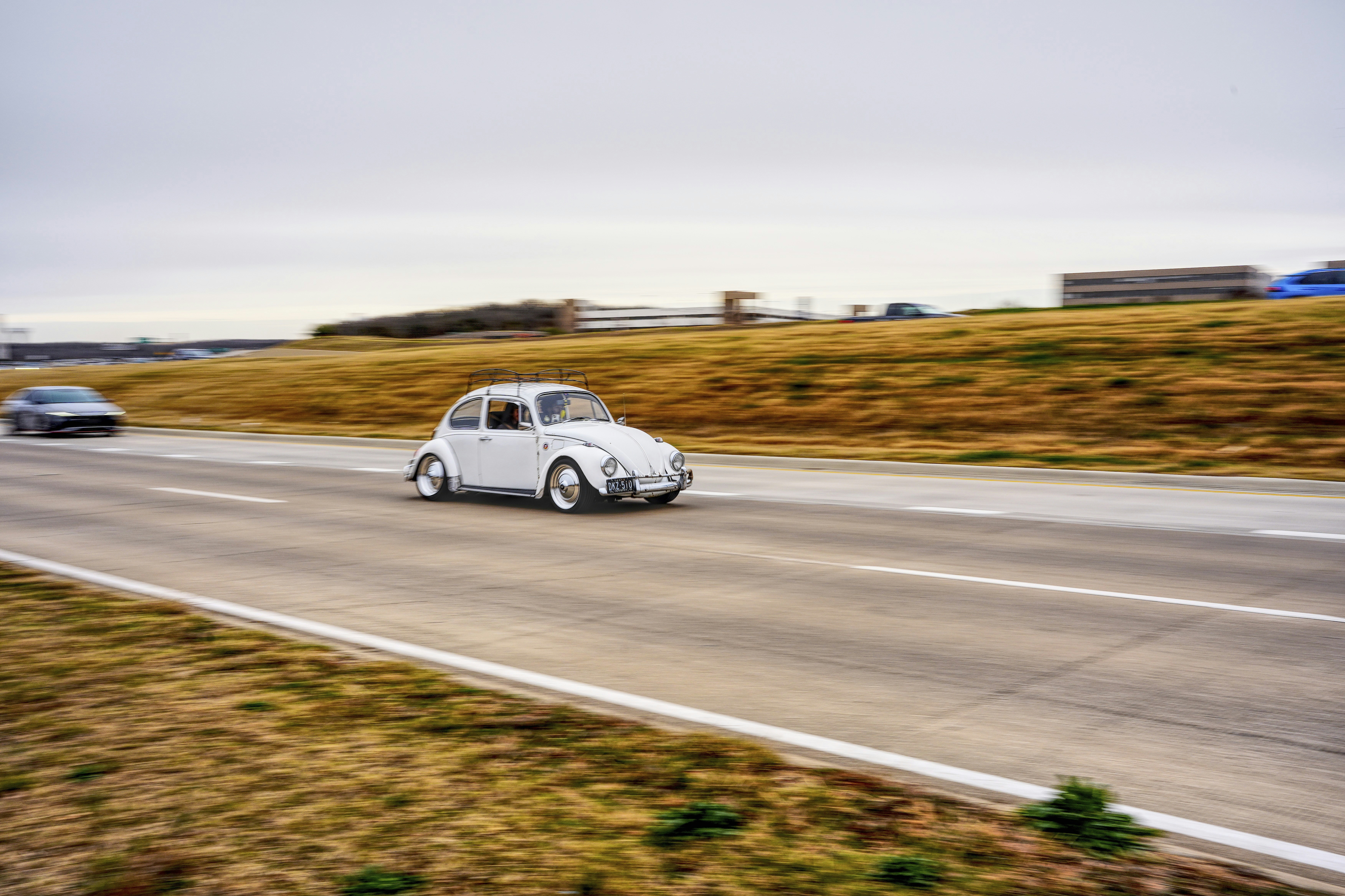 White Beetle on a Quiet Highway: A Gentle Blur of Speed and Dusk