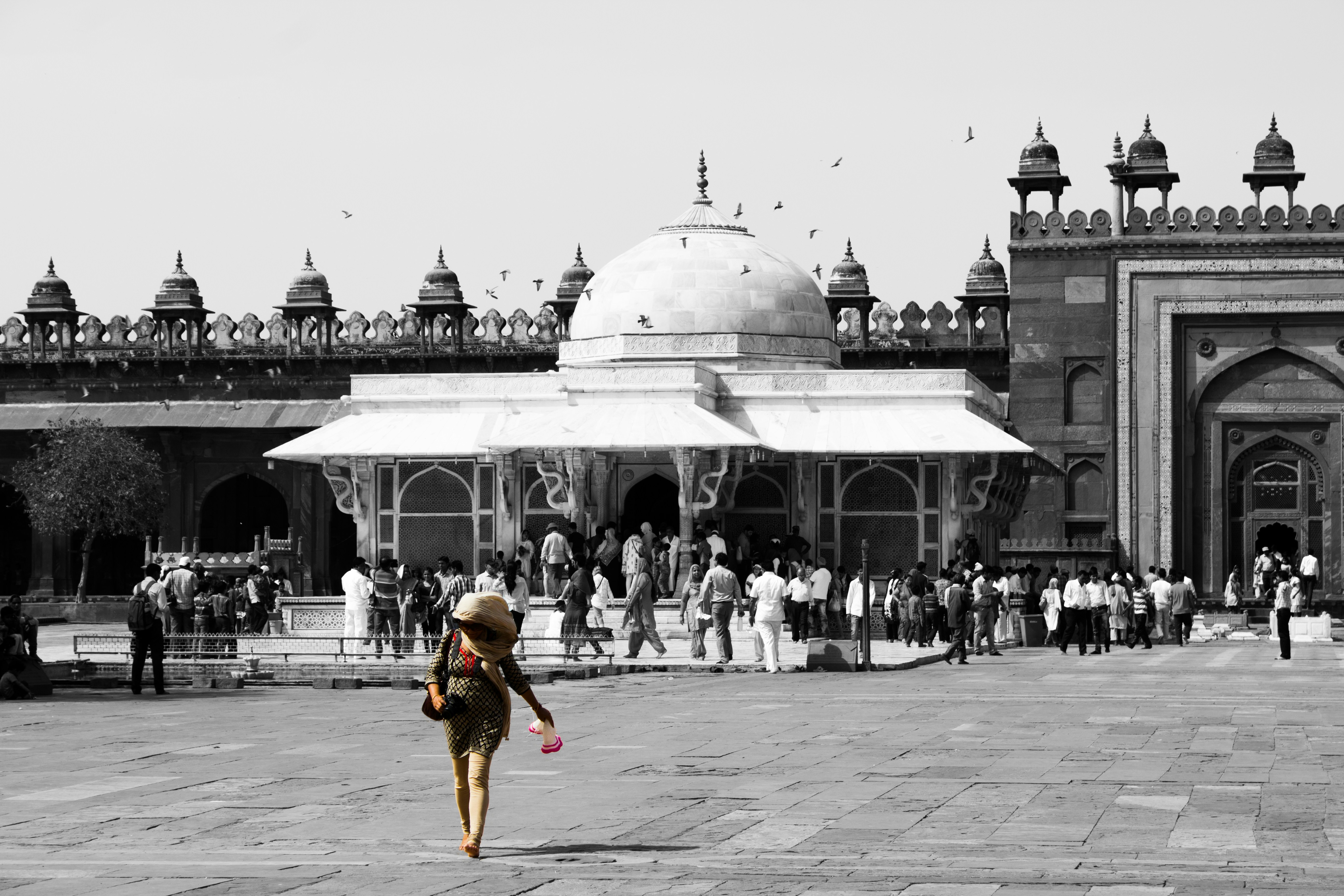 Traveler with a Straw Hat Crossing a Historic Plaza