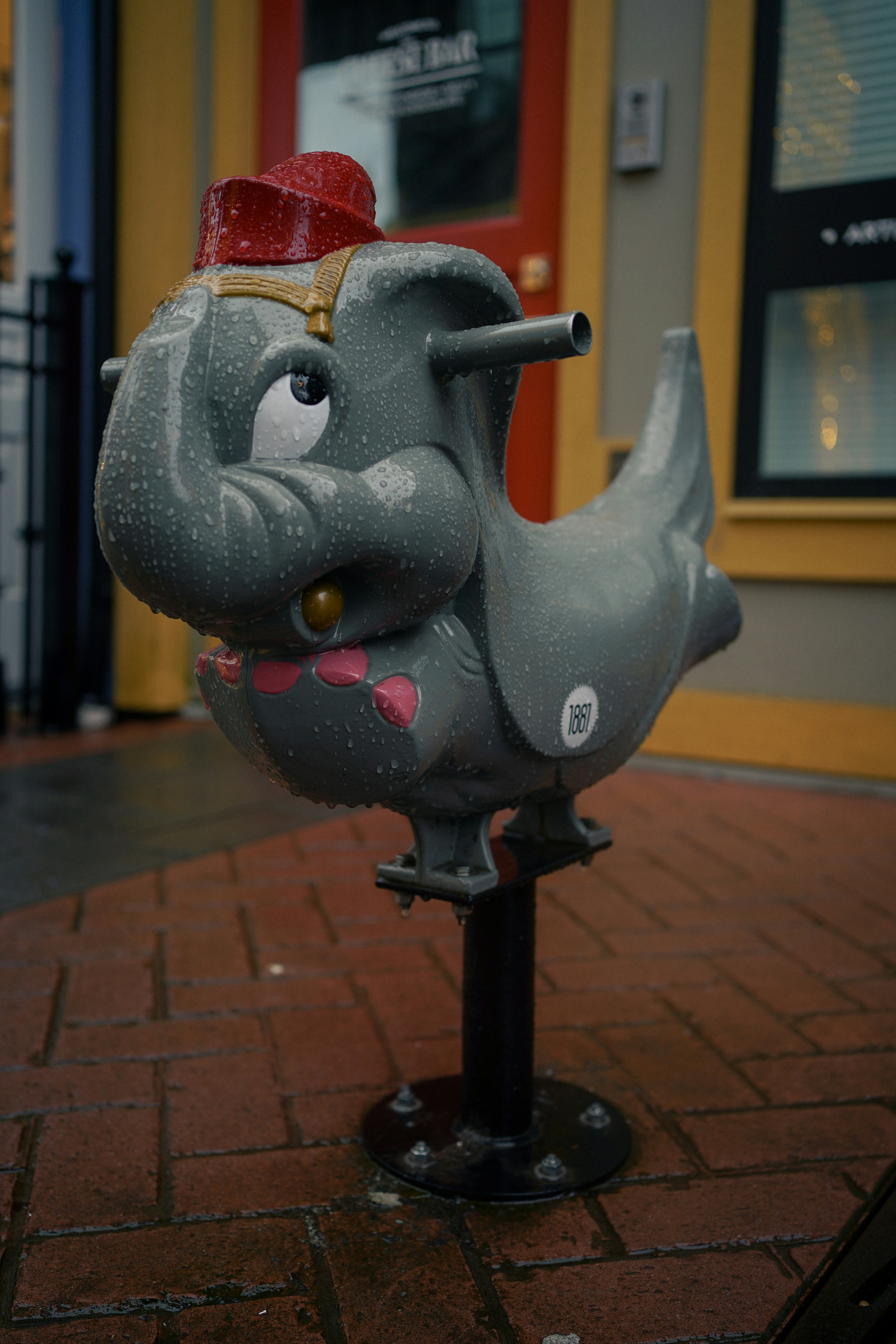 Rain-kissed Elephant on a Pedestal: A Damp Day in the Arcade