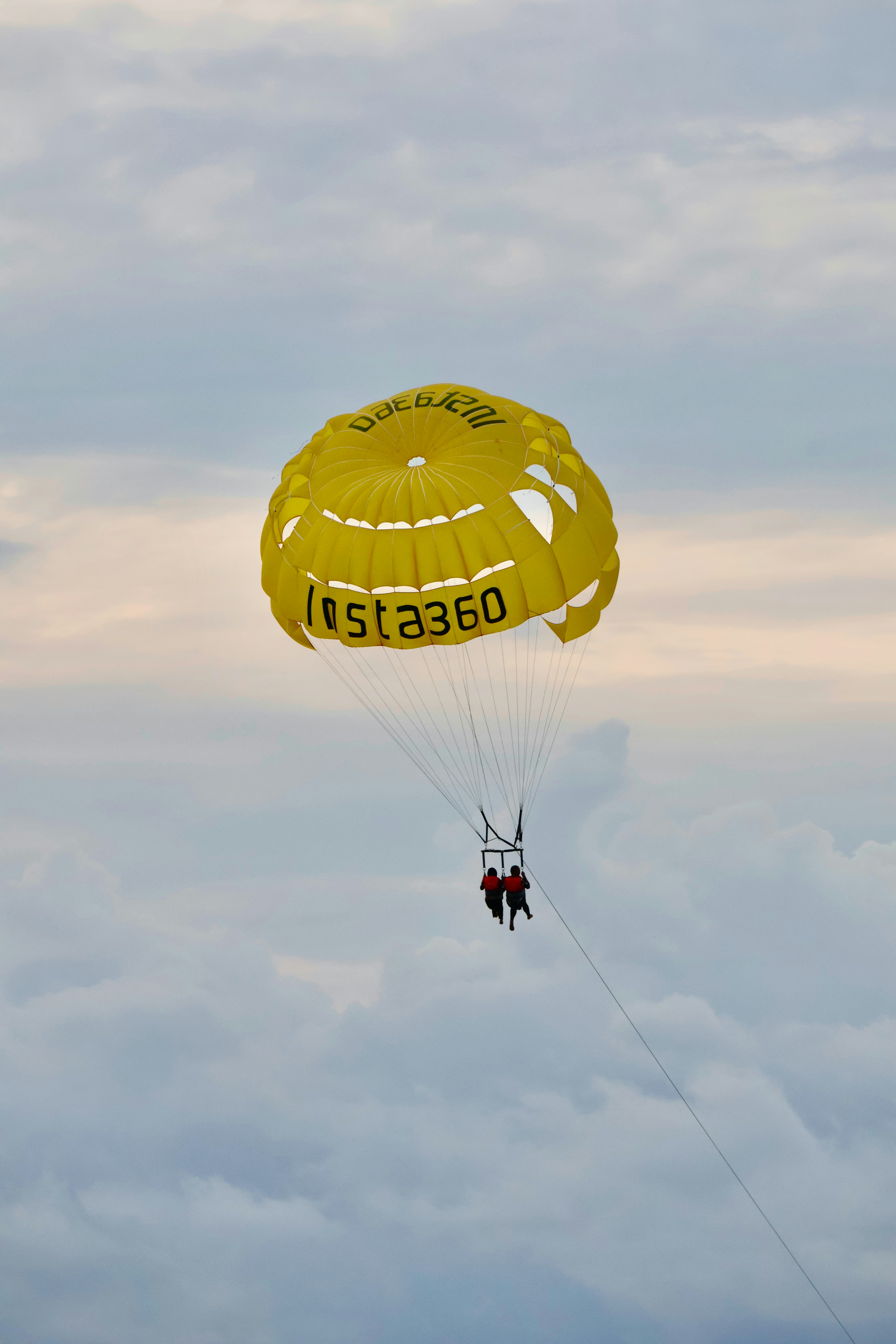 Yellow Parachute Over Clouds: Aerial Duo in Flight