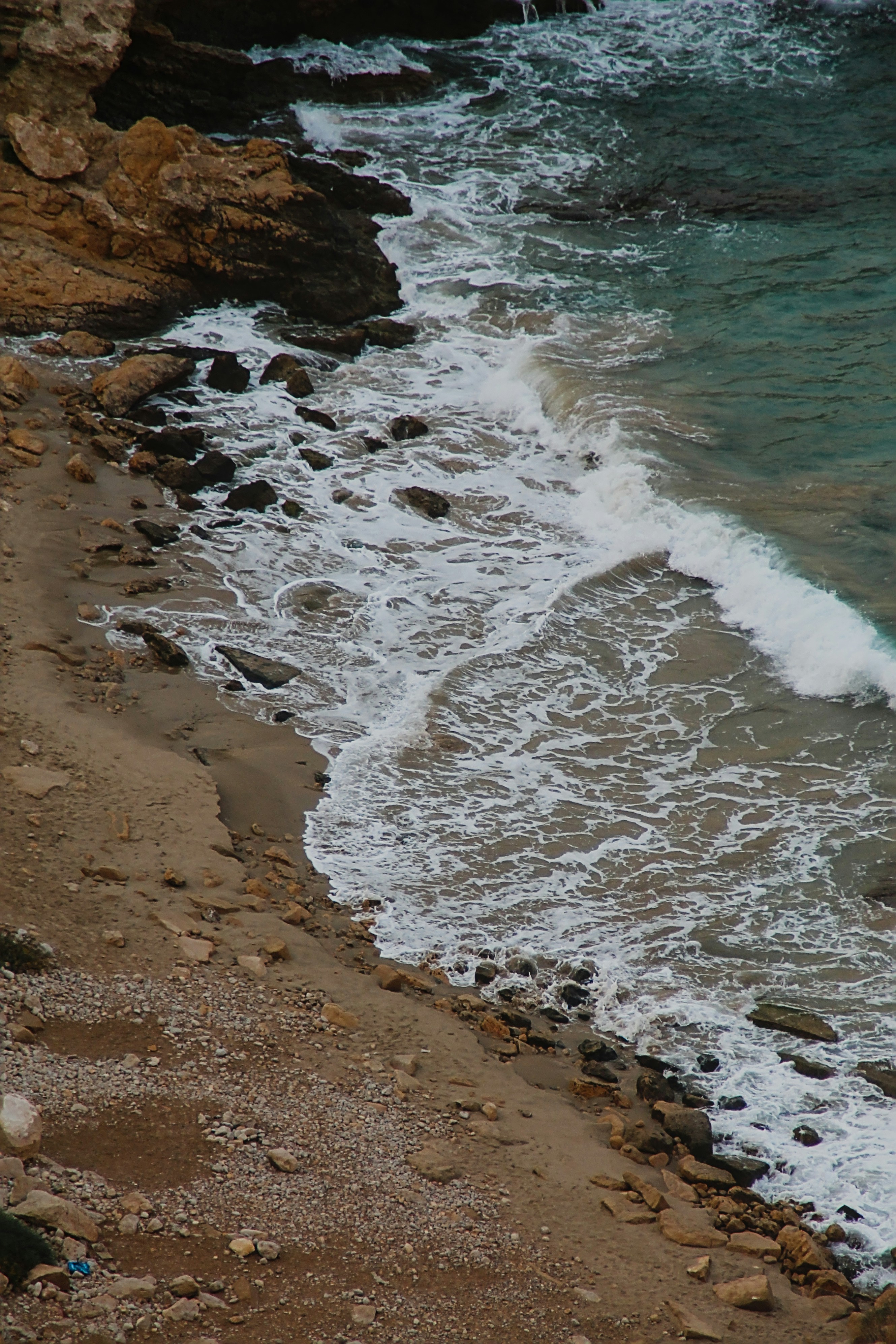 Cliffside Shoreline: Tumbled Rocks Meet Turquoise Seas