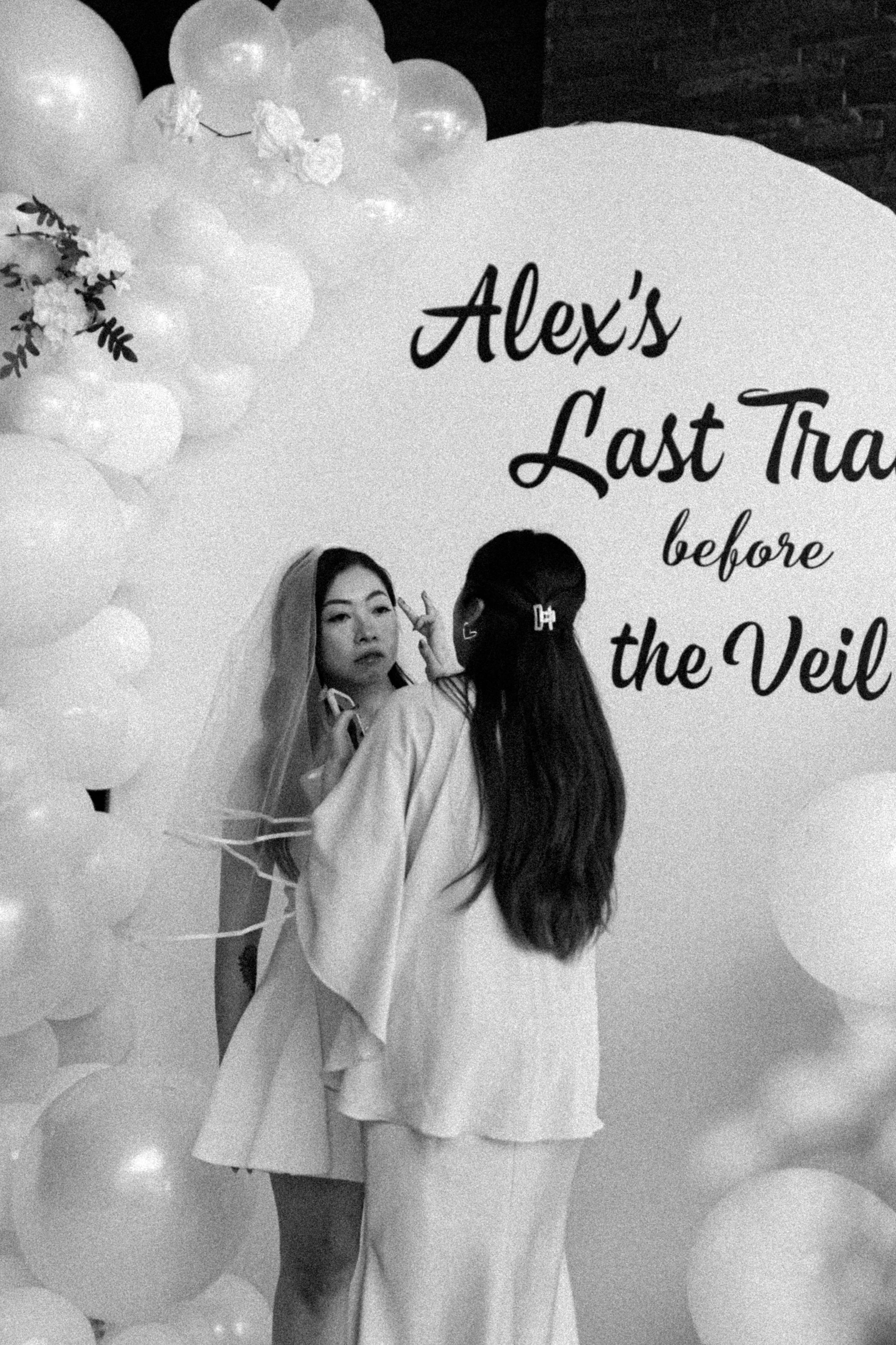 Veiled Vows: Quiet Exchange Amid Balloon Arches