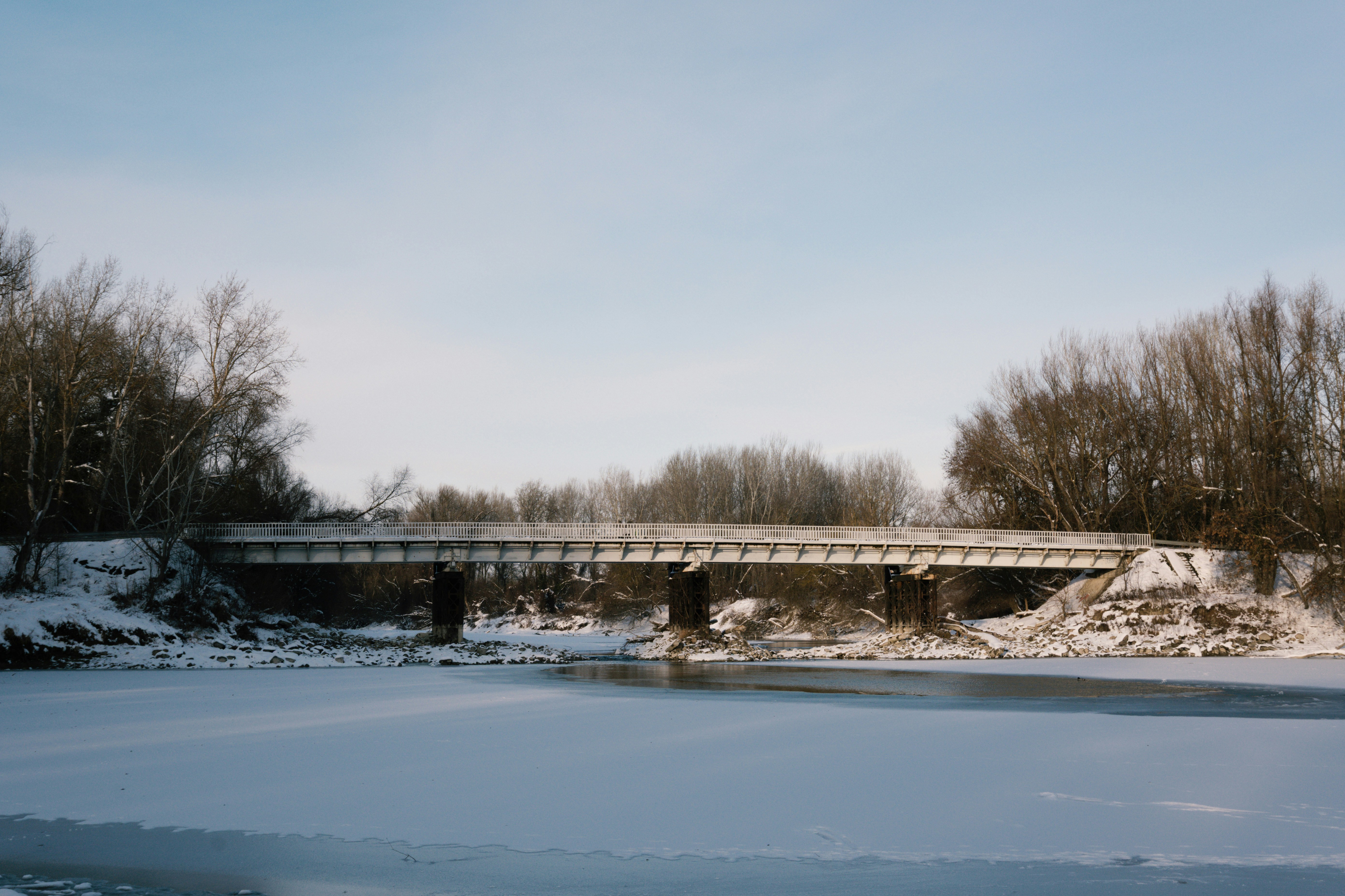 Snowbound Bridge Span Over a Quiet Icy River