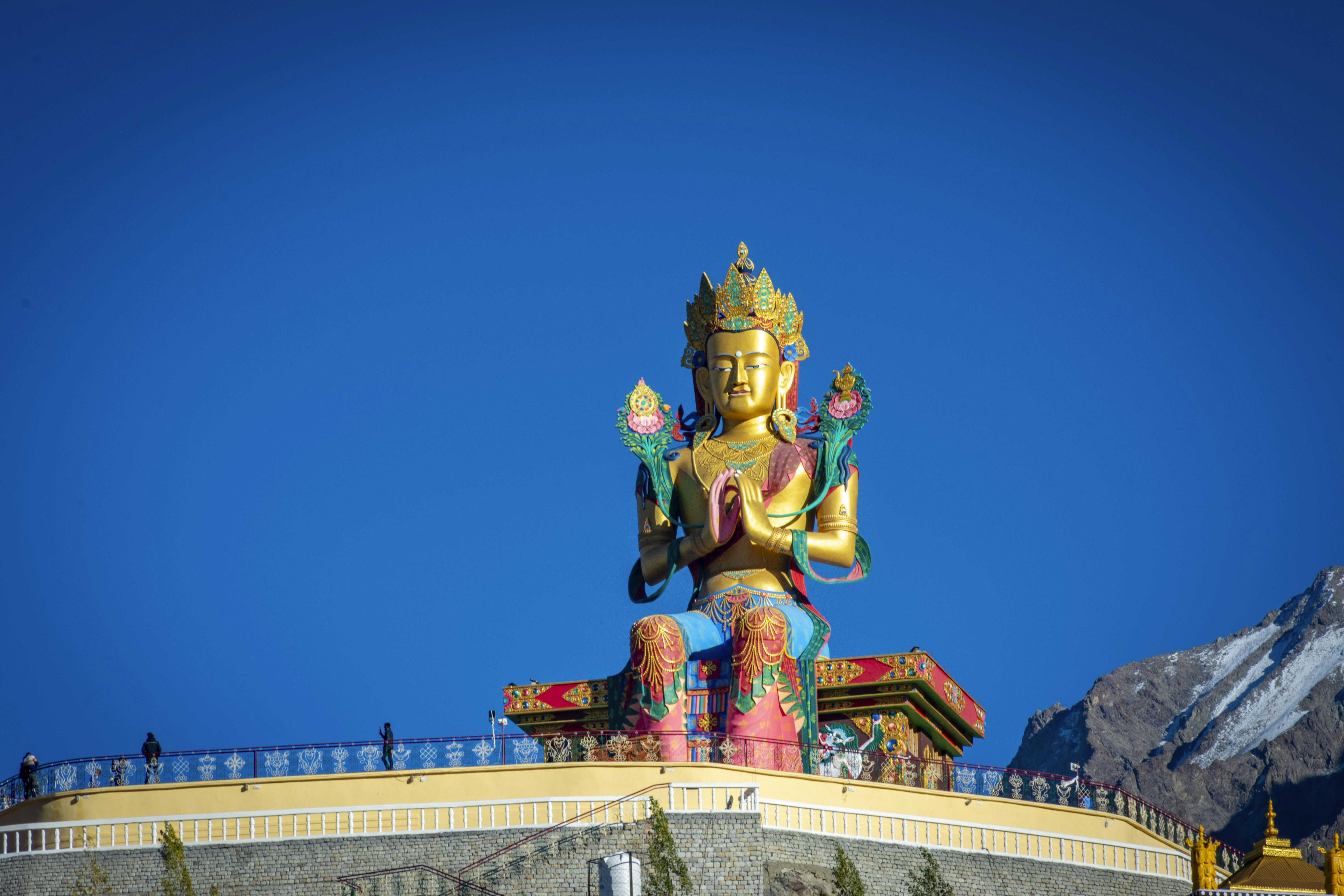 Golden Buddha Ascendant under a Clear Alpine Sky