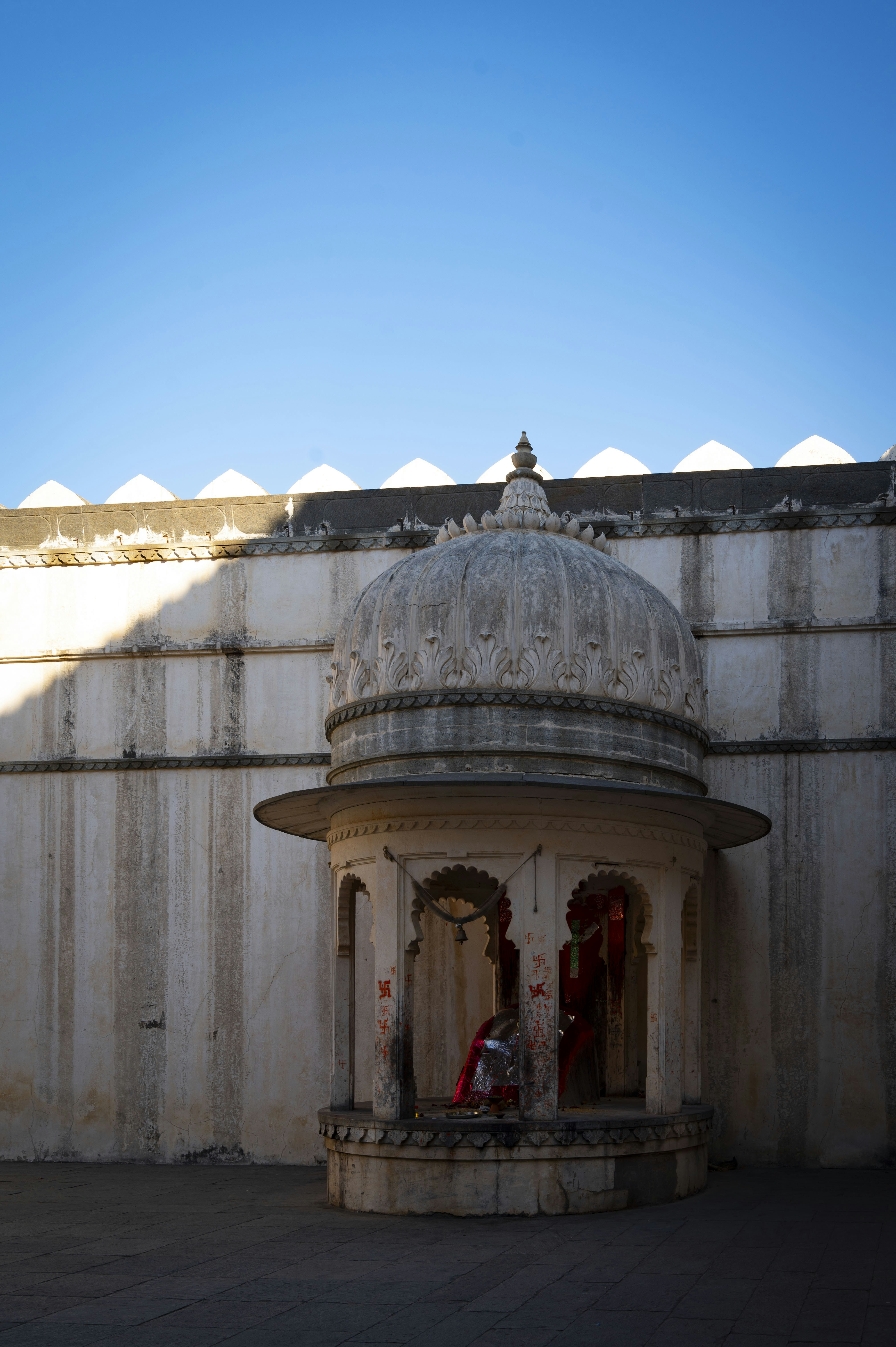 Deserted Shikhara Shelter: A Sunlit Dome Against a Walled Horizon