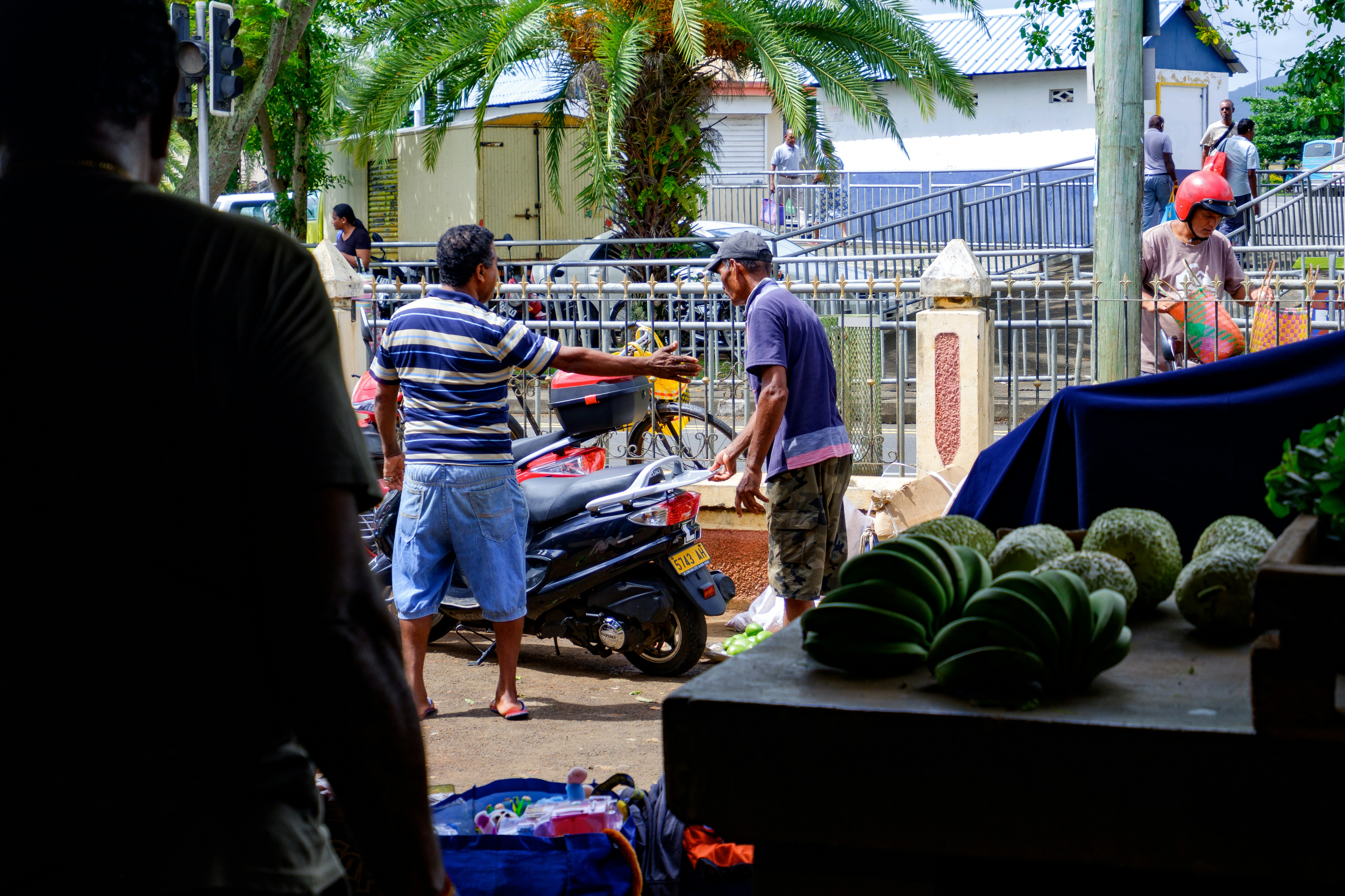Market Moment: Vendor and Scooter Amid Busy Street