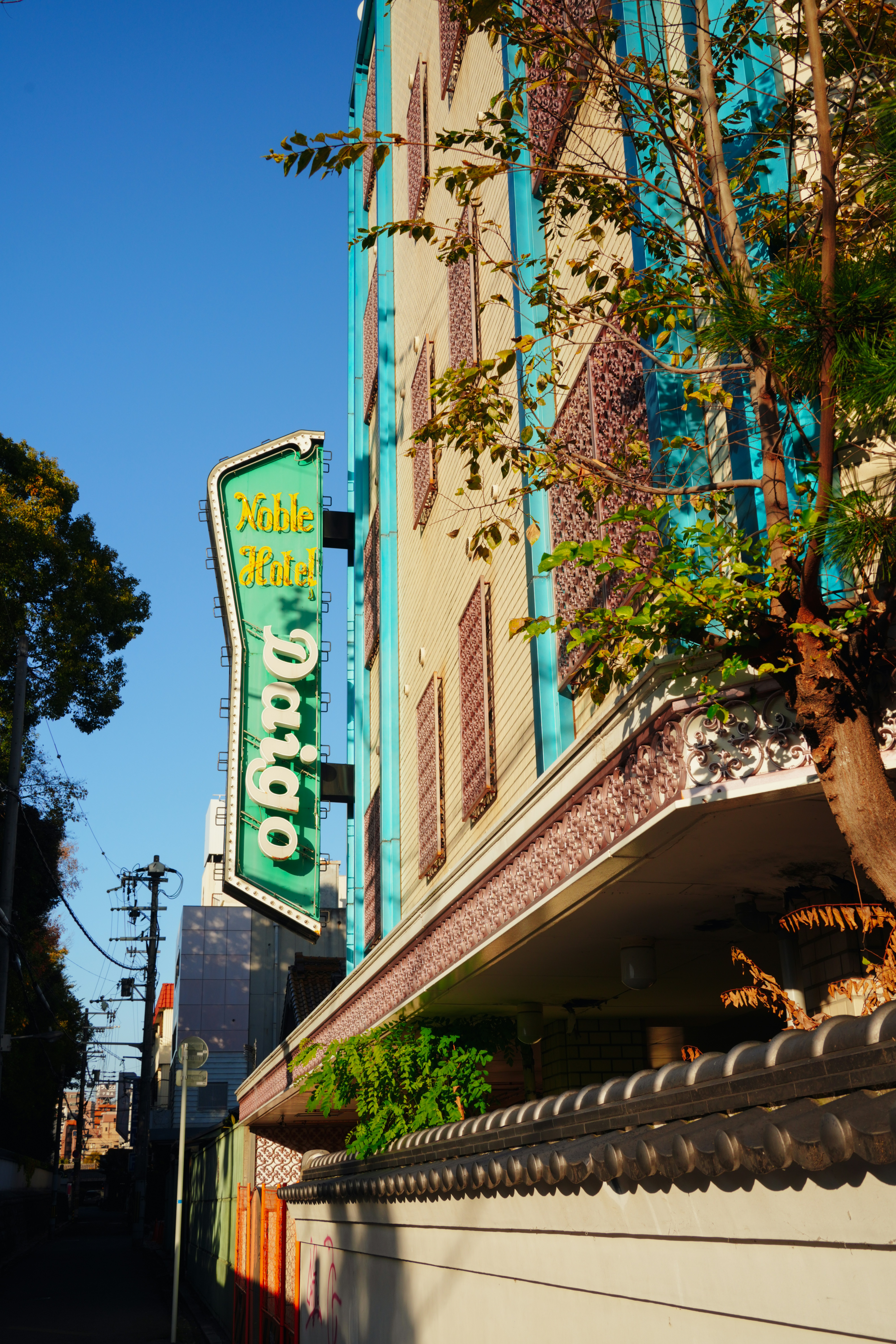 Dimensional Neon: Noble Sign, Sunlit Facade, and Shaded Alley