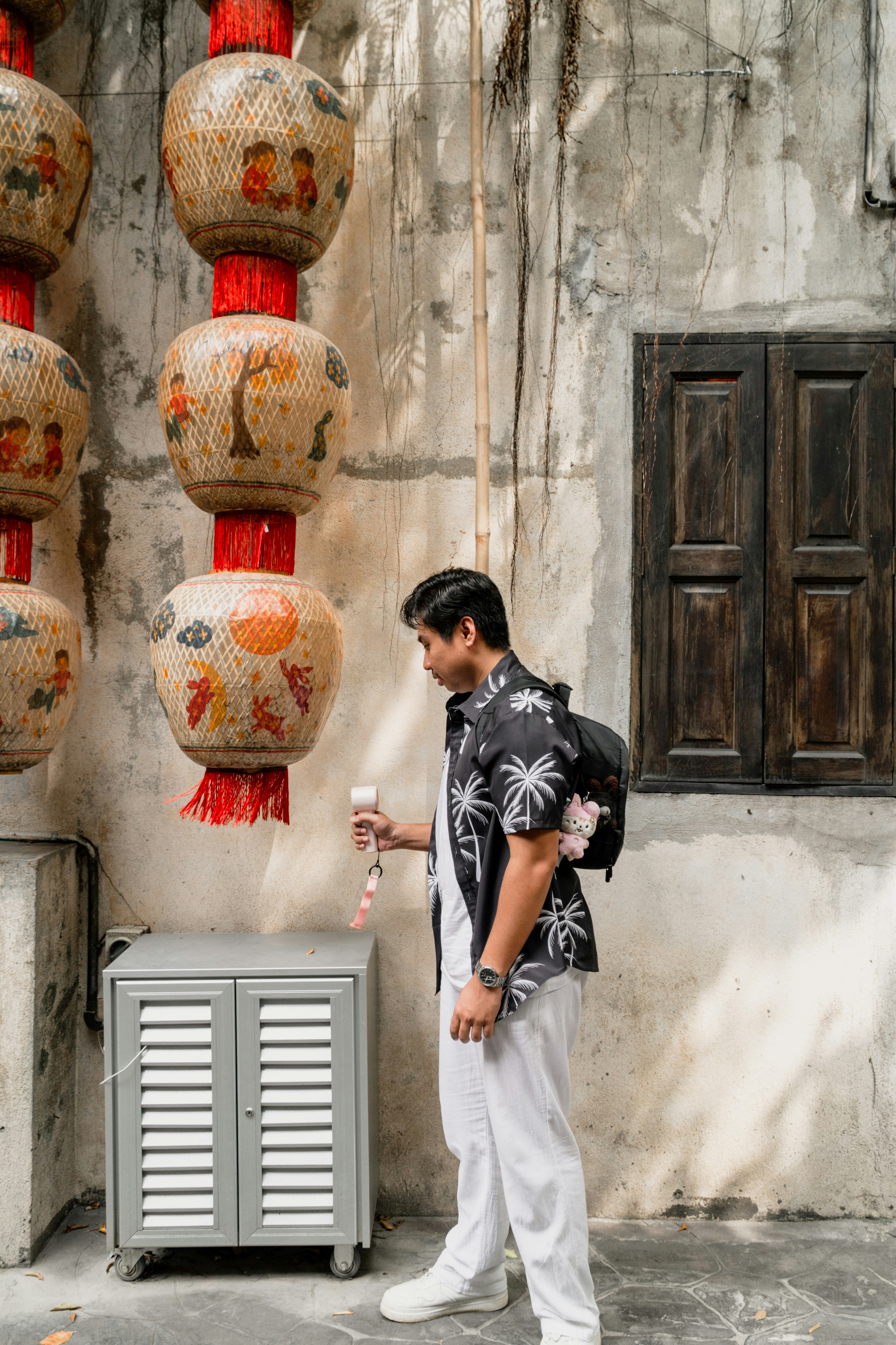 Traveler with a striped candy at the lantern-lined wall