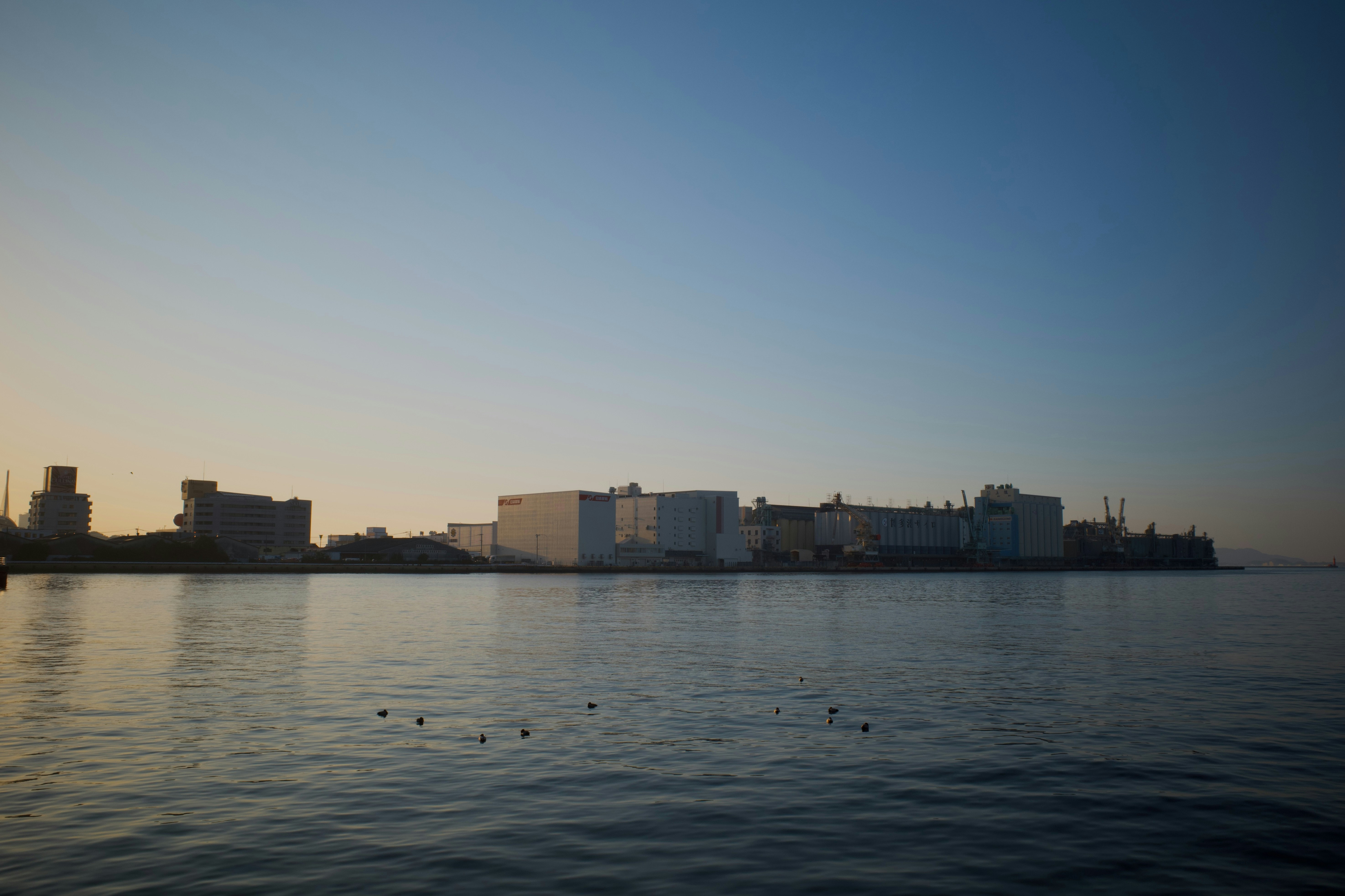Sunlit Waterfront Factory Row at Dusk