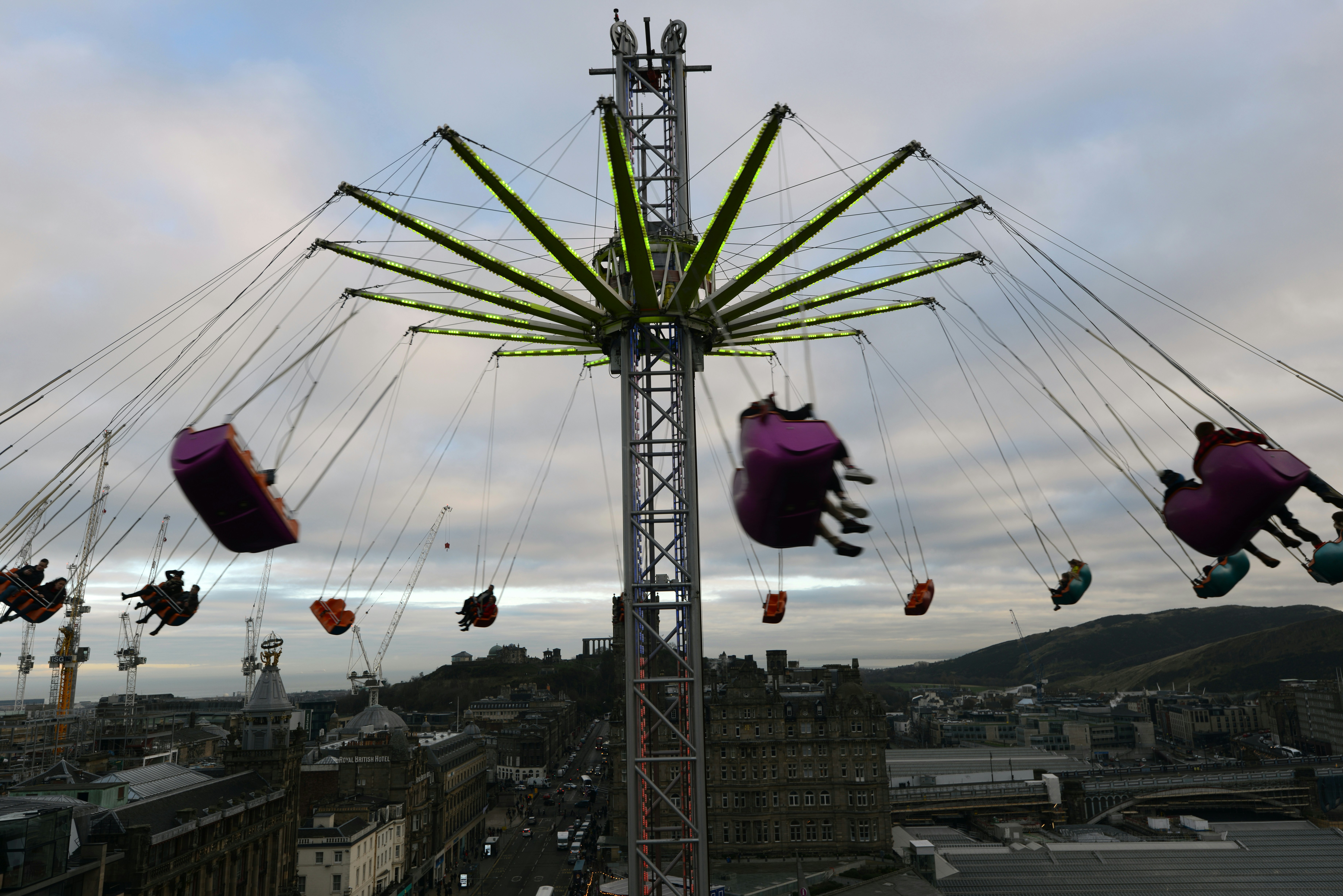 Skyward Swing: A City Below the Turquoise Spokes