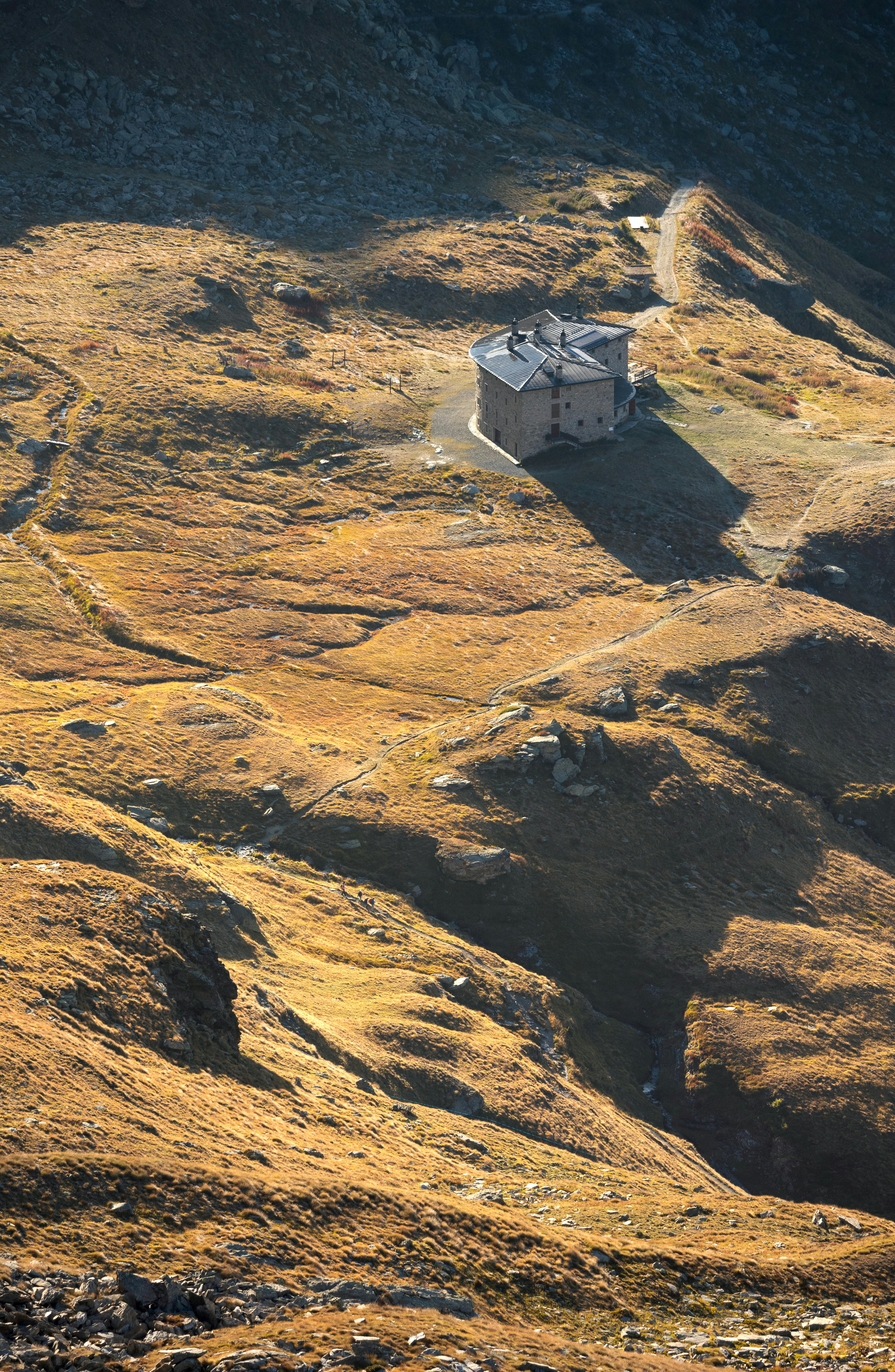 A remote building sits on a grassy mountainside. photo – Free Travel ...