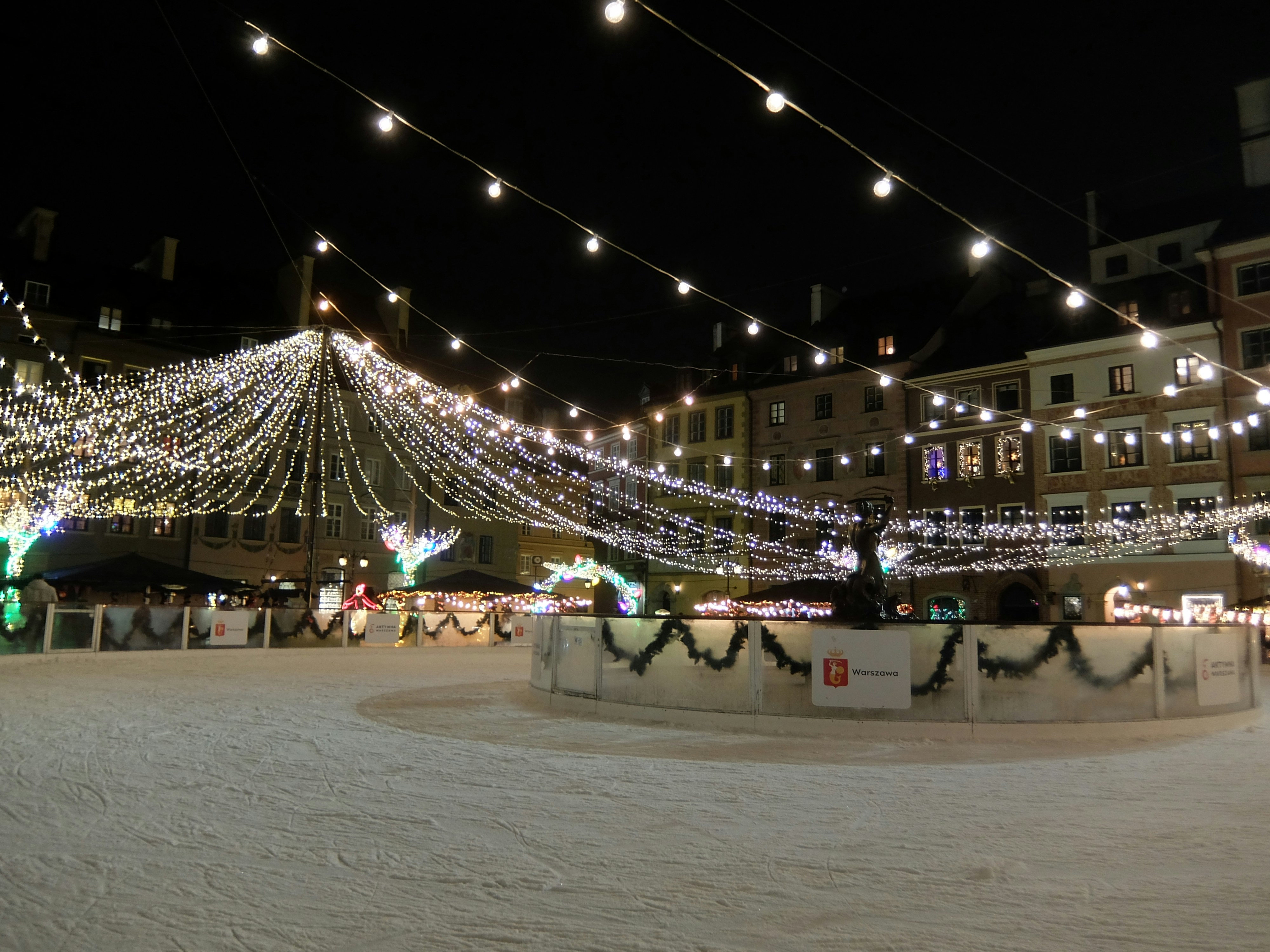 An outdoor ice rink decorated with christmas lights