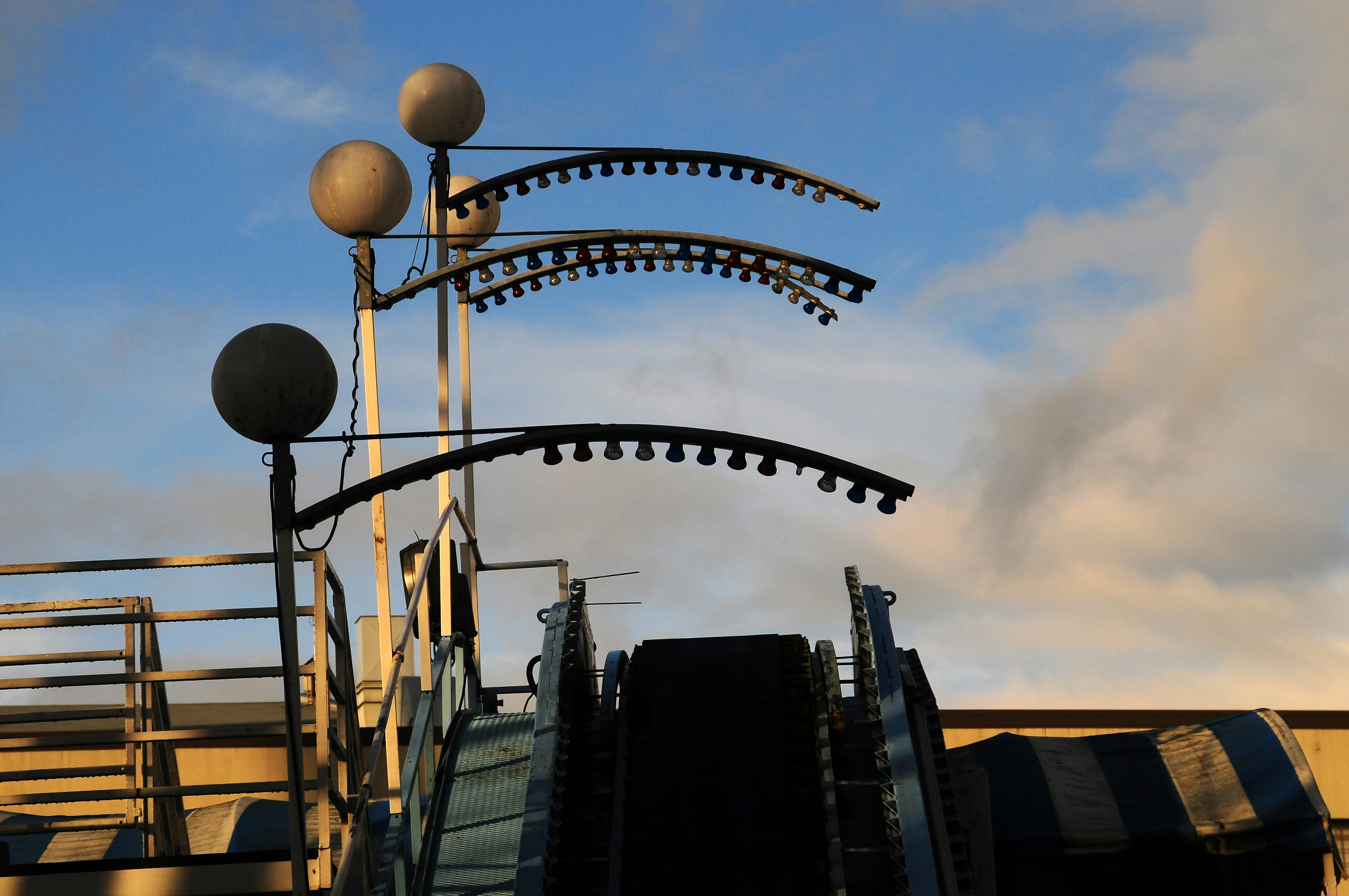 Mid-arc silhouettes: a skyline of looping support arms against a blue-sky backdrop