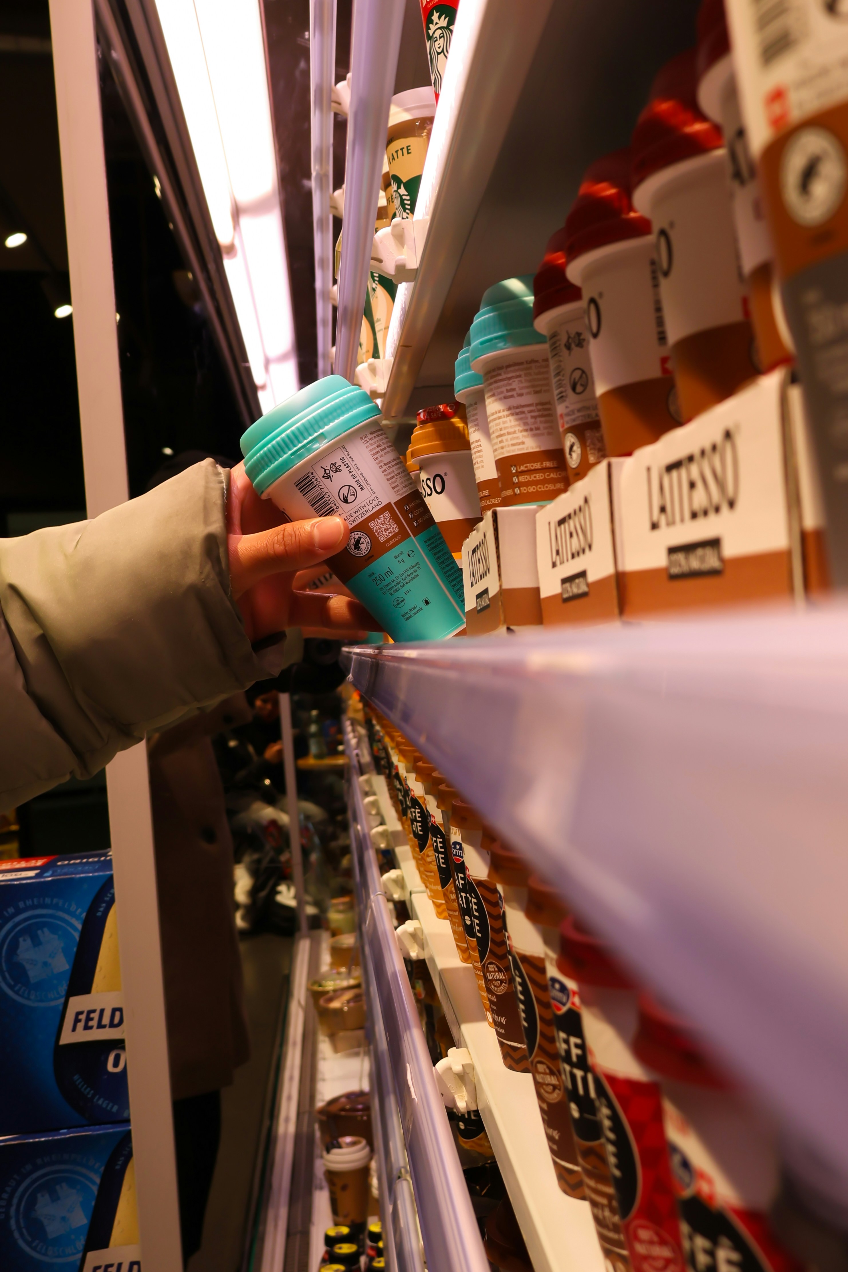 Scooped Latte To-Go: A Hand Reaches for a Drink on a Store Shelf