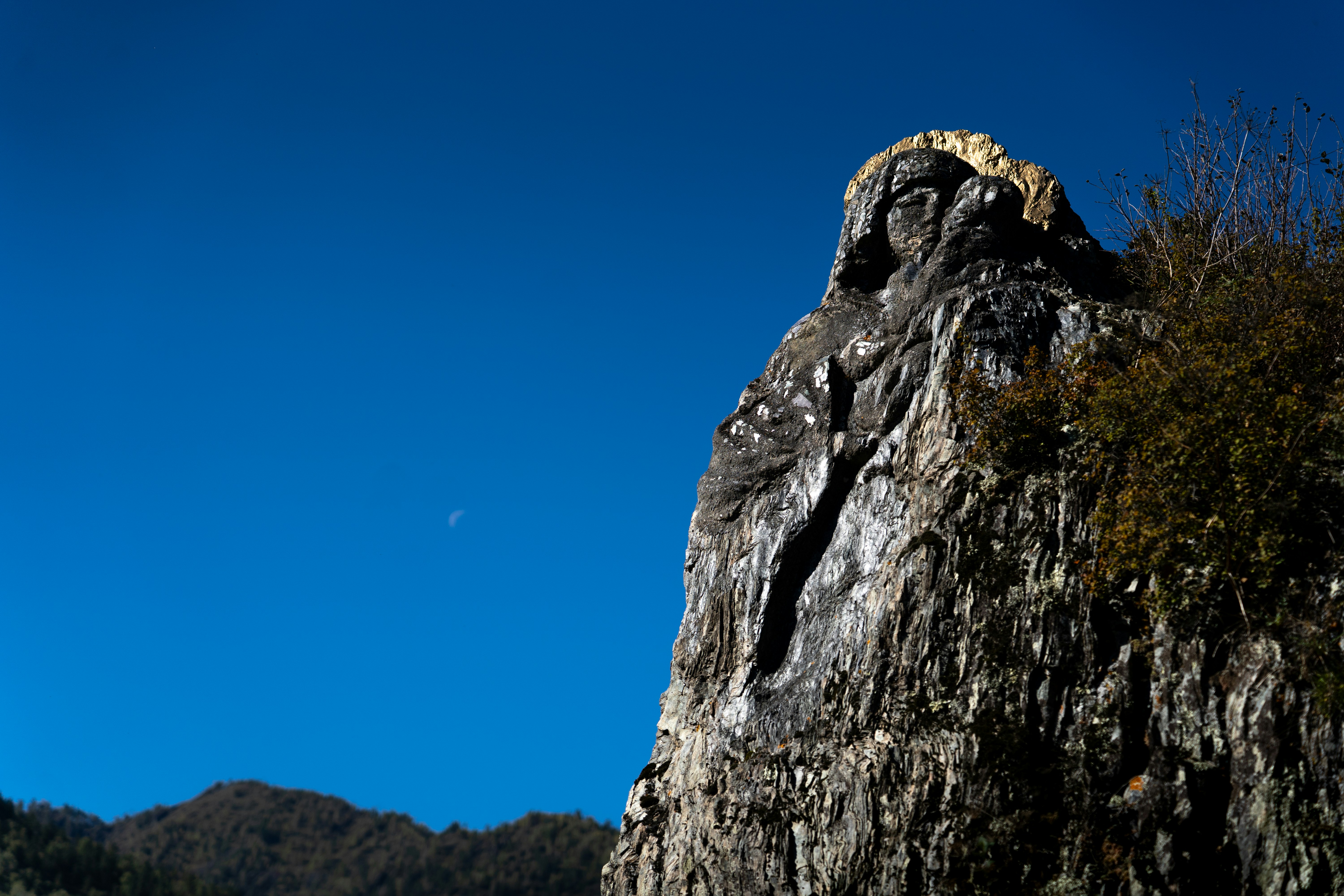 Majestic Carved Sentinel: A Lone rock Face Against a Sky of Blue