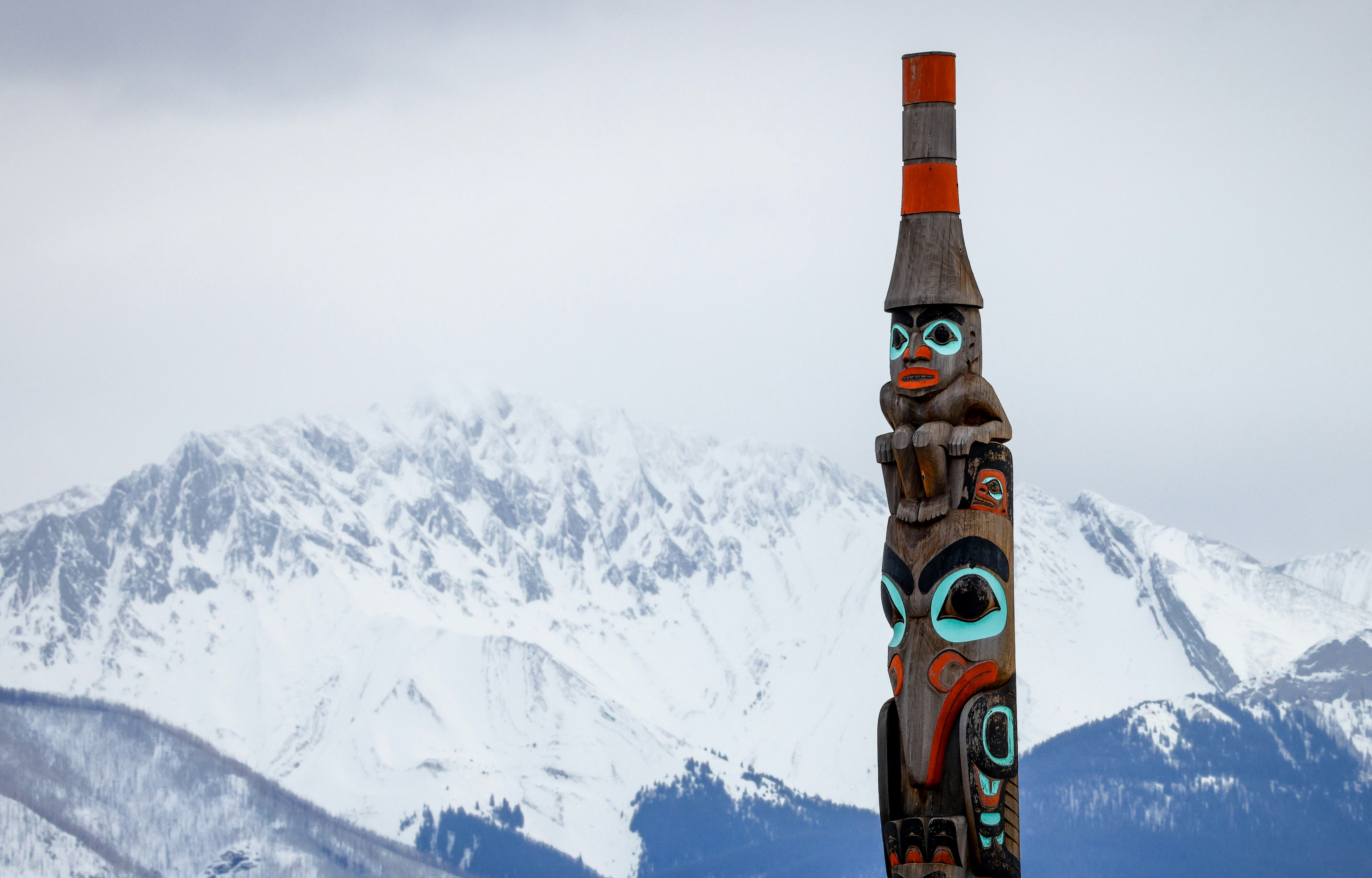 Totem of Snow: A Tiki Pole Rising Against the Alpine Sea