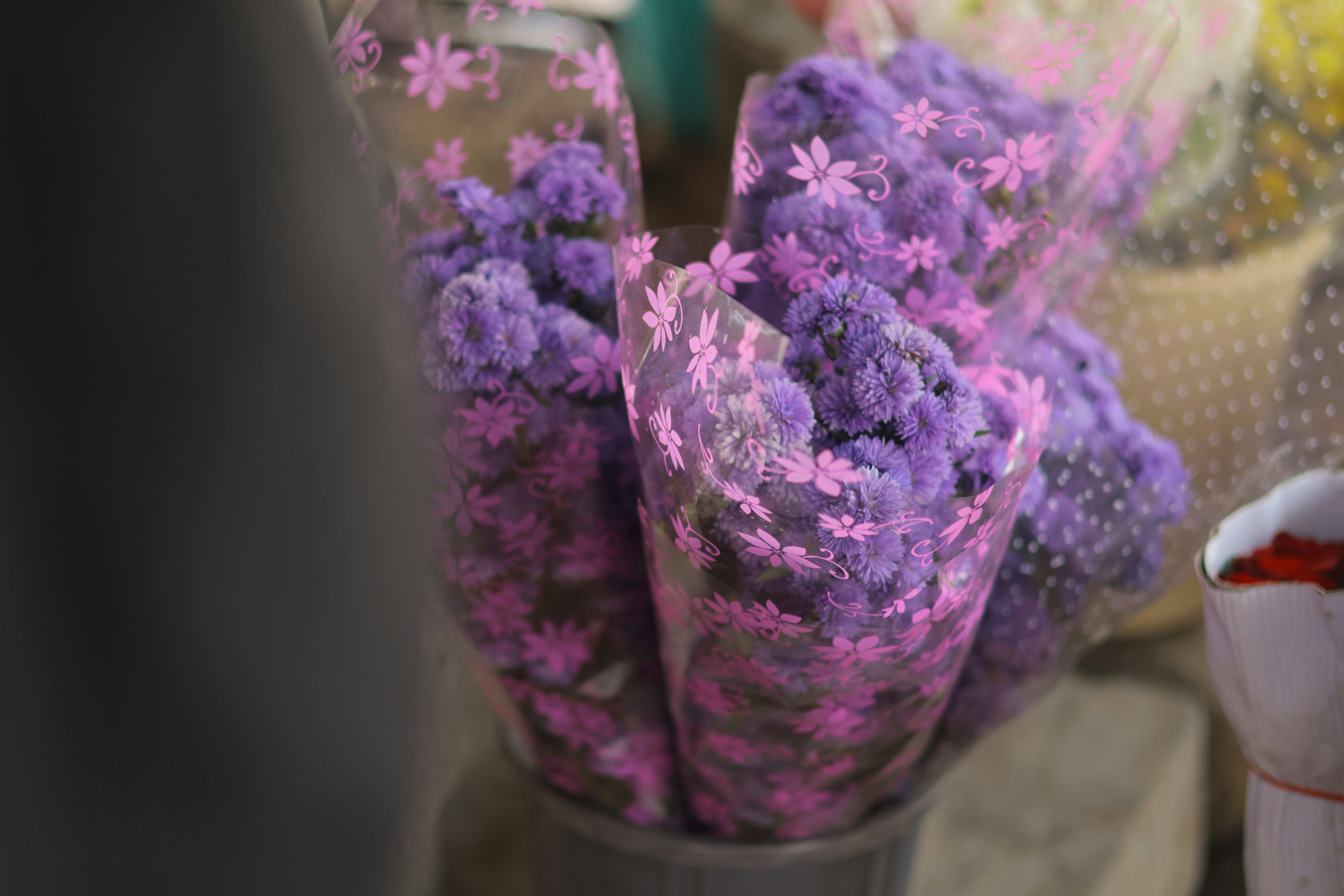bouquets of purple flowers put in a small bucket at a flower shop