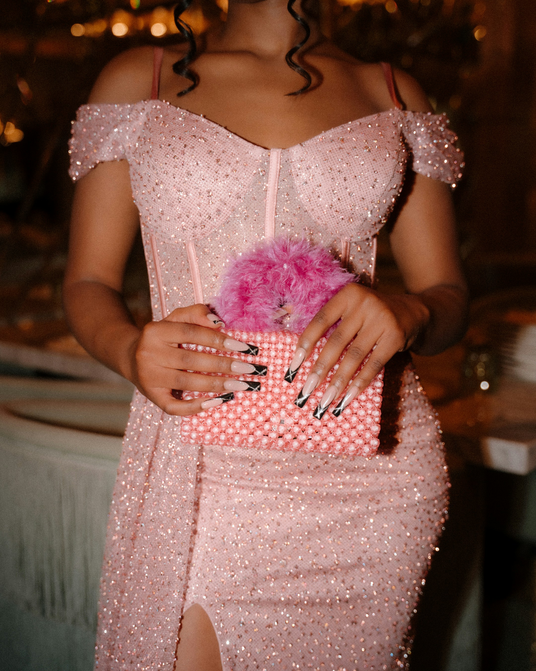 Soft pink glamour: a celebratory moment with feathered clutch
