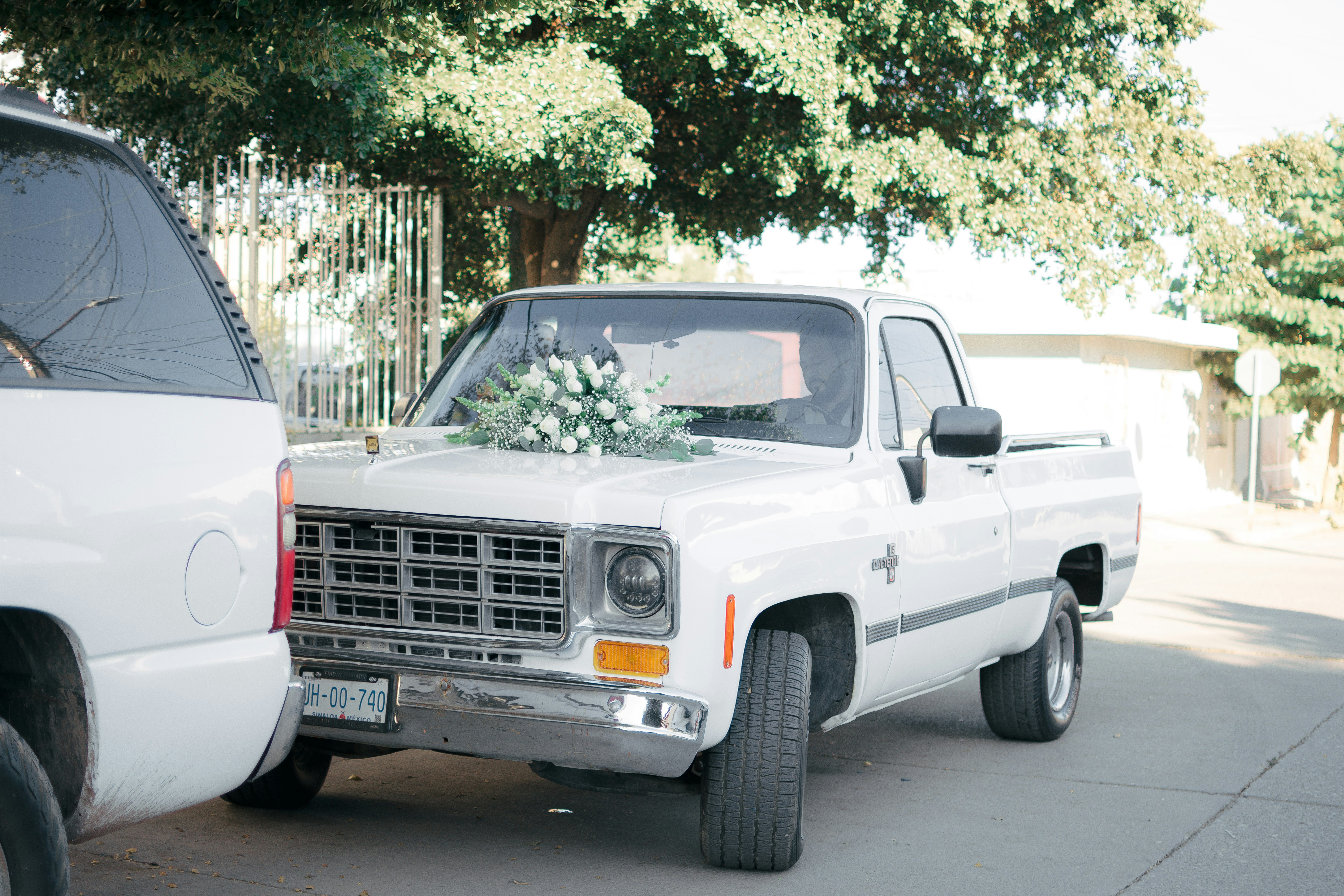 Wedding Wheel: A White Pickup Adorns the Driveway with Floral Escort